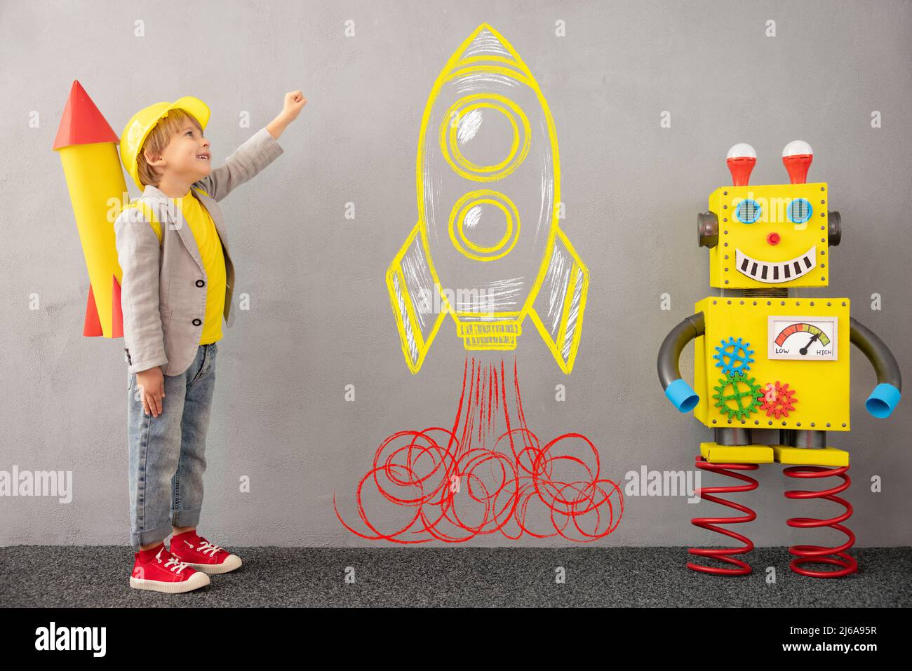 Happy child with rocket and robot. Funny kid playing at home. Success ...