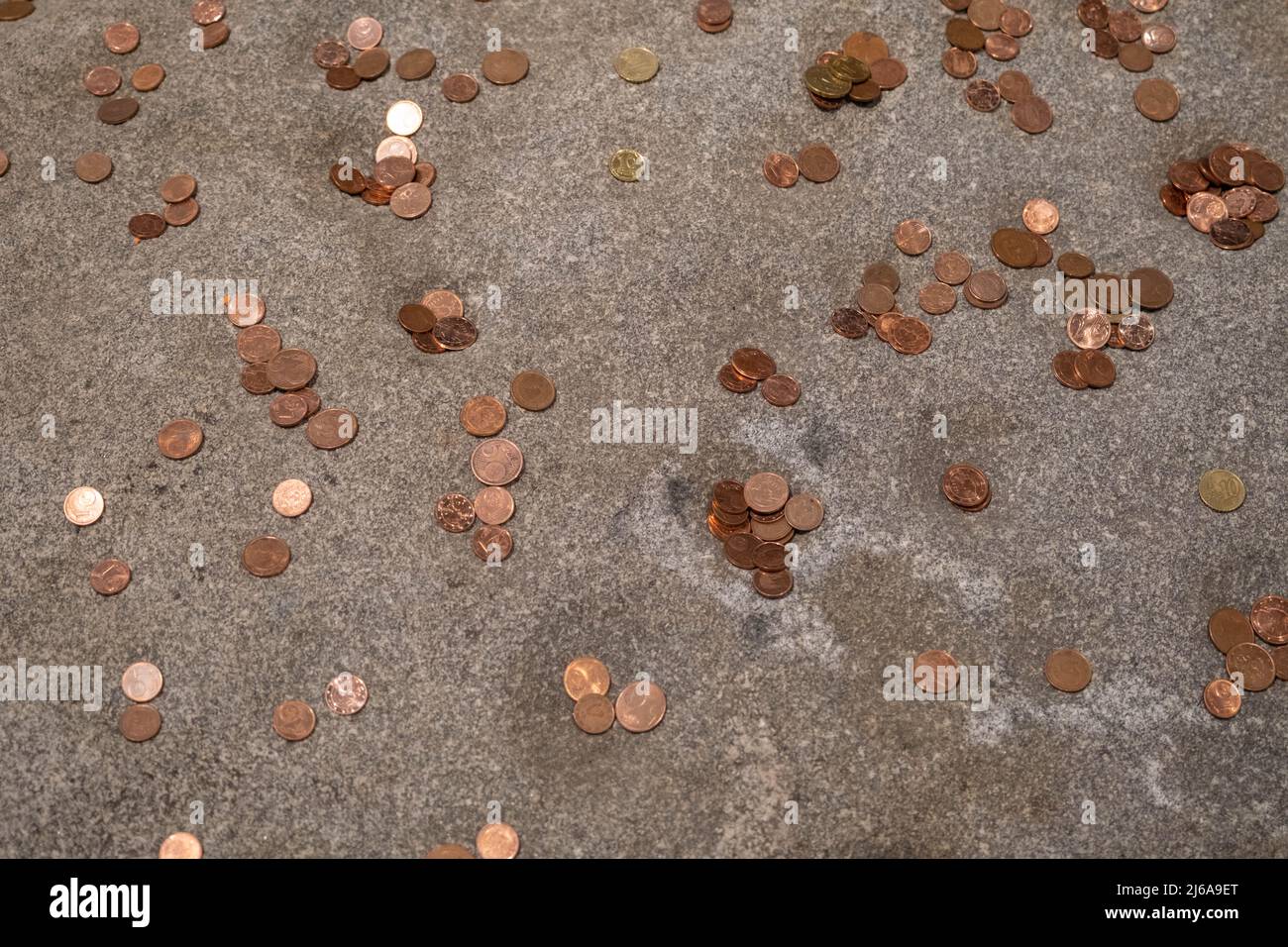 Coins of different countries of the world are left on stone to be ...