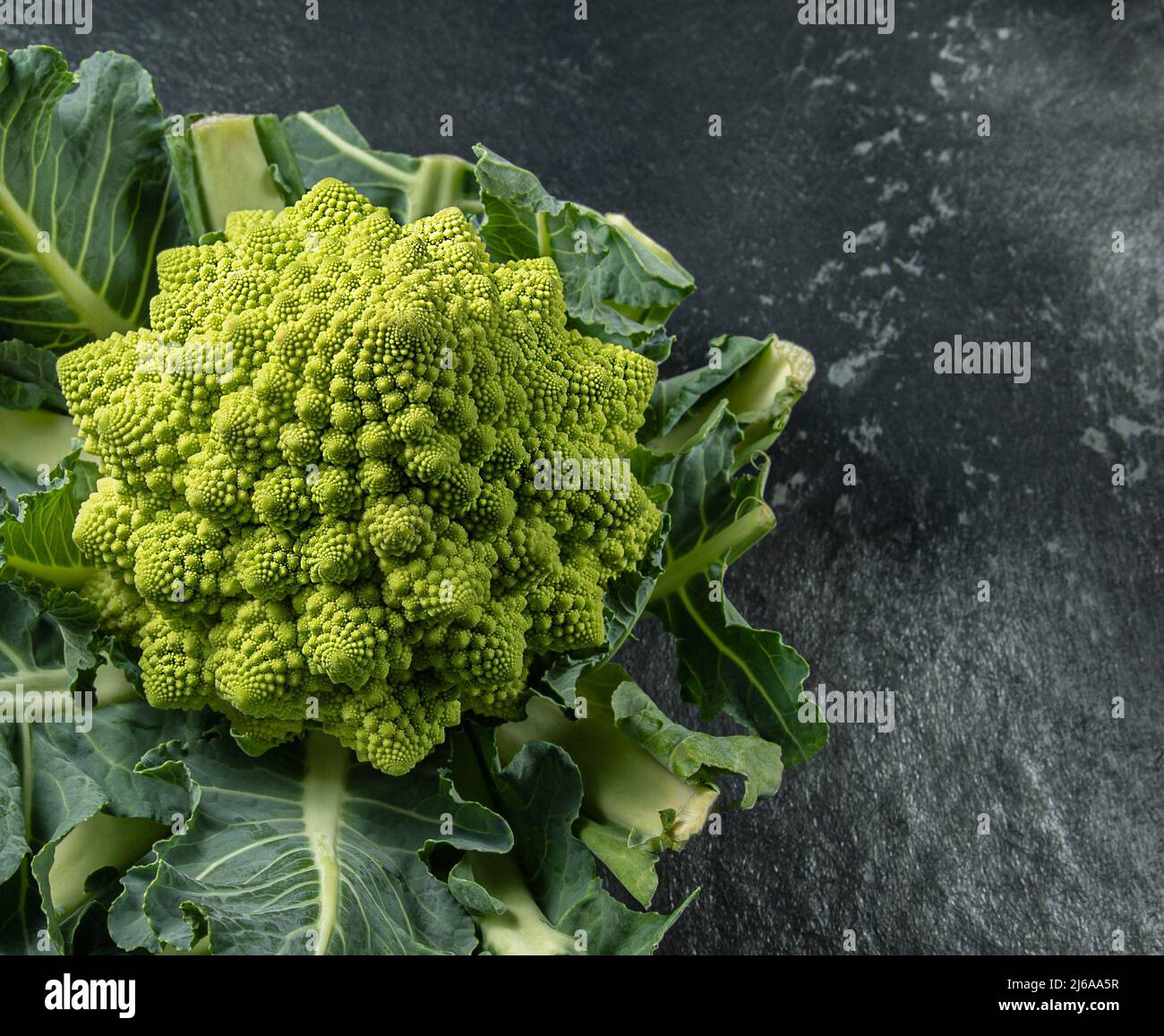 Romanesco broccoli head on a dark stone surface, cabbage, close up ...