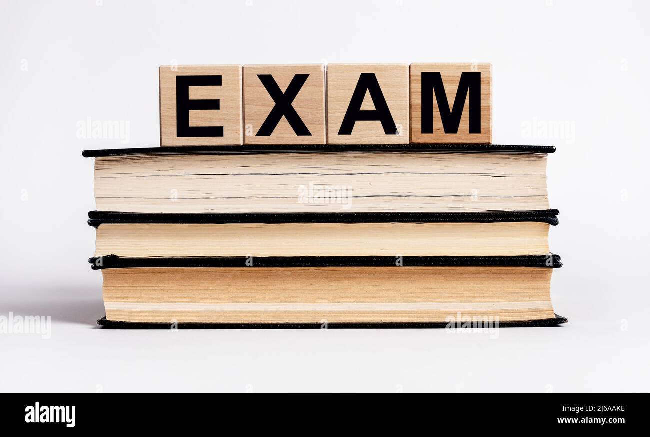 Word exam on Books stack with wooden blocks. Preparation for ...