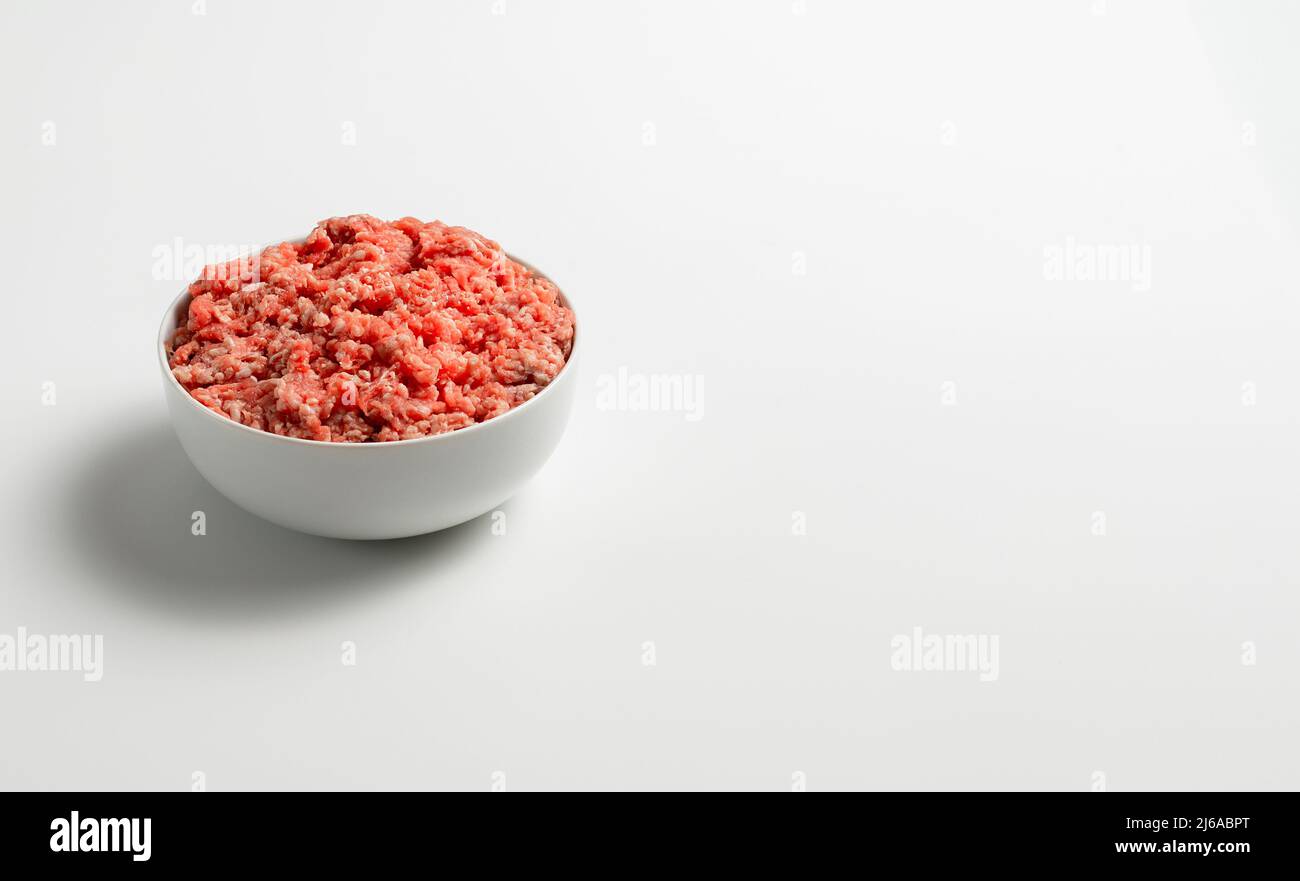 Plate with fresh ground beef on a white background, space for text ...