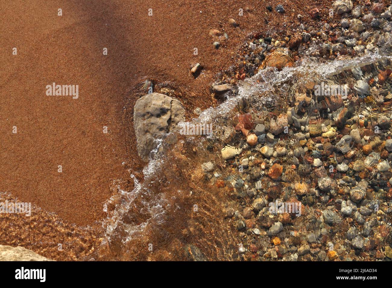 Small Waves Rolling into Sandy Beach Dotted with Colorful Pebbles ...