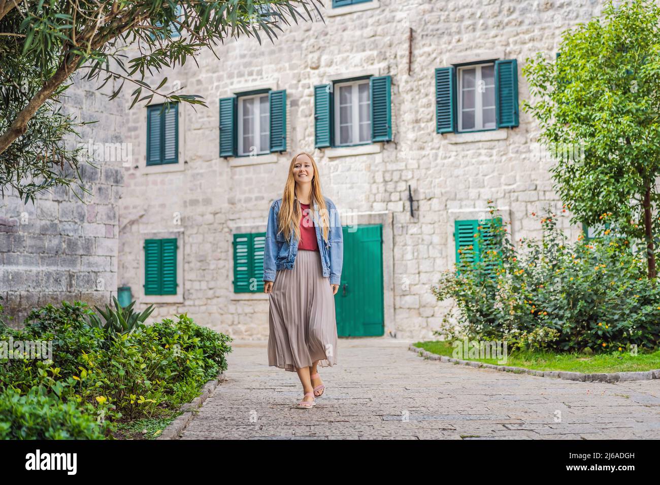 Woman tourist enjoying Colorful street in Old town of Kotor on a sunny ...