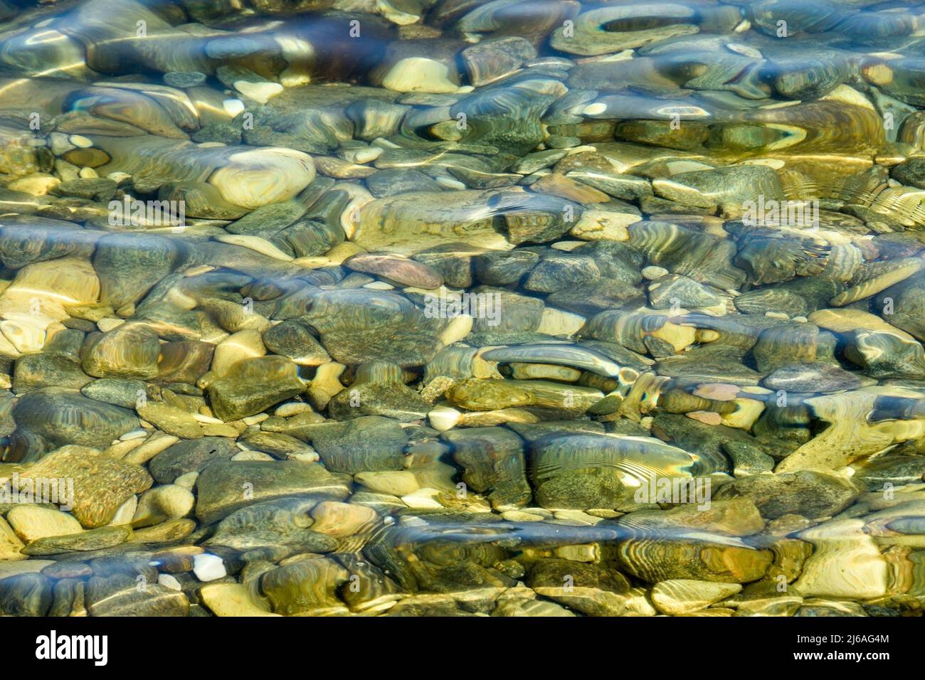 Crystal clear water with stones as a background Stock Photo - Alamy