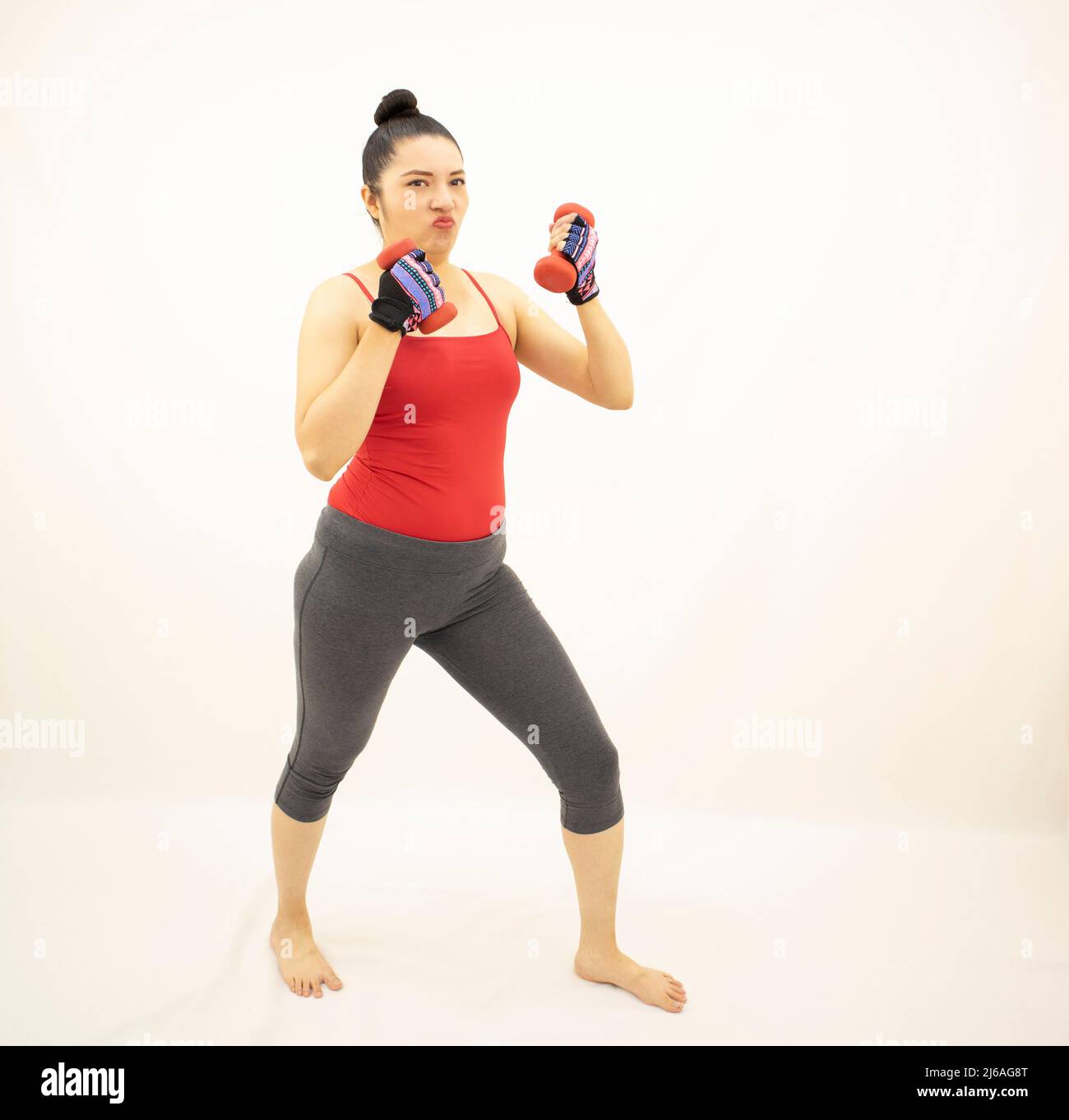 beautiful athletic woman in gray sportswear, red t-shirt, practicing ...