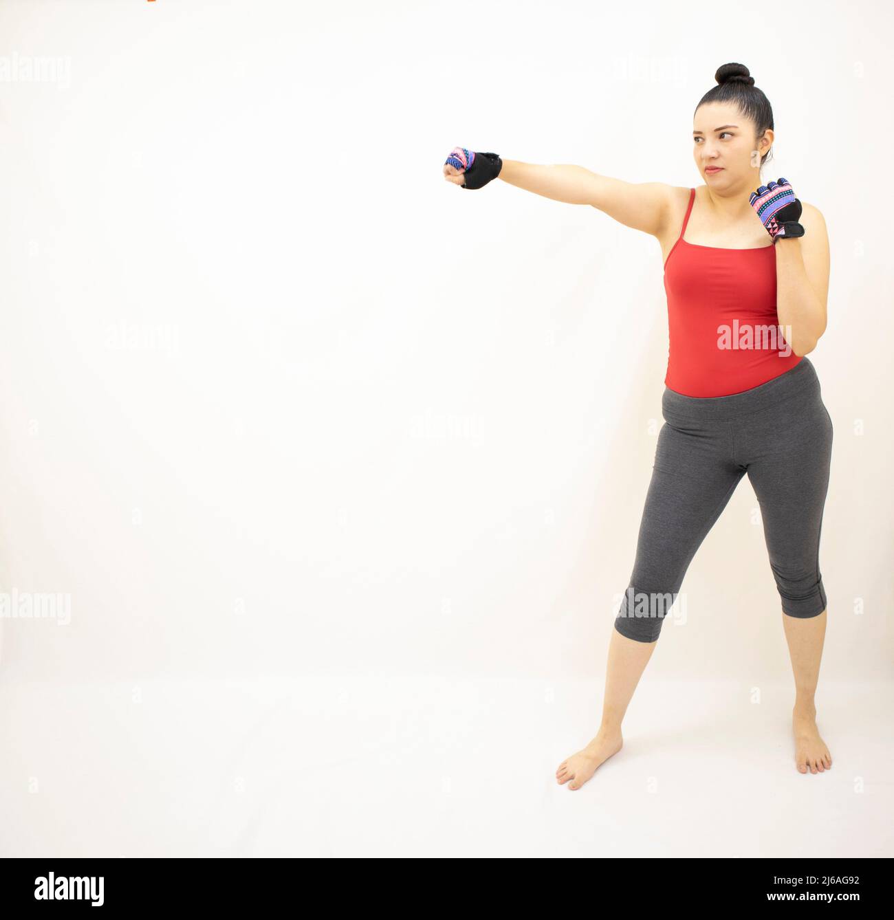 beautiful athletic woman wearing gray sportswear, red top, practicing ...