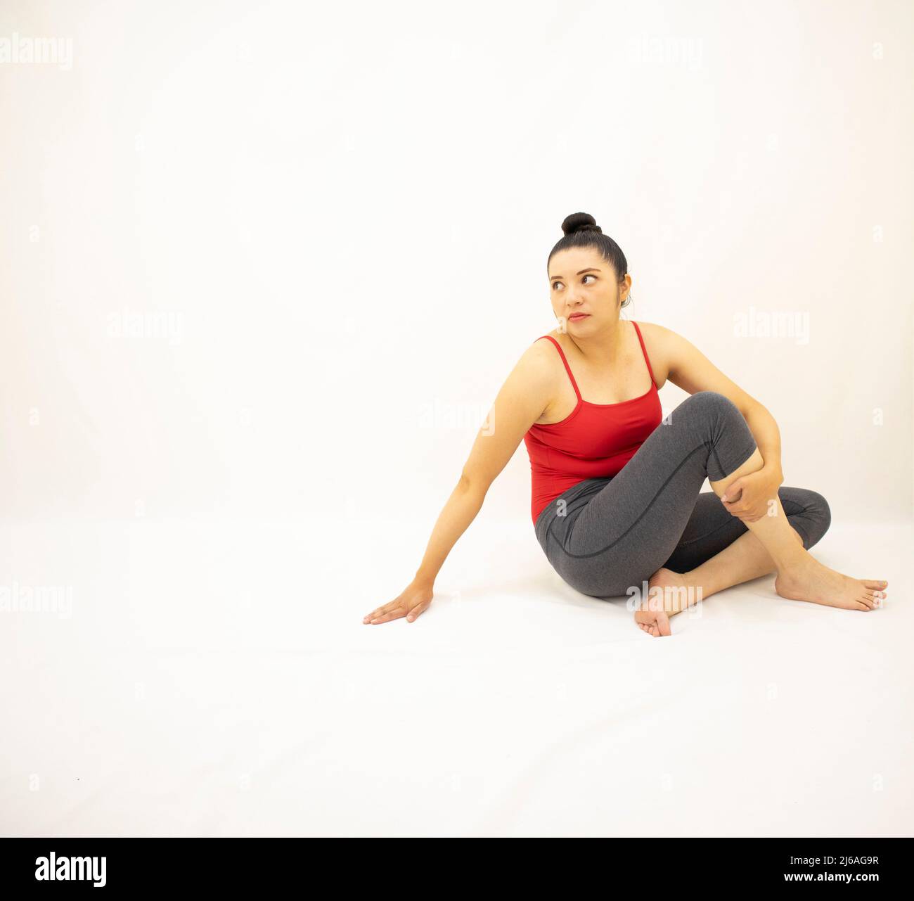 athletic woman in gray sportswear, red blouse, sitting contemplating ...