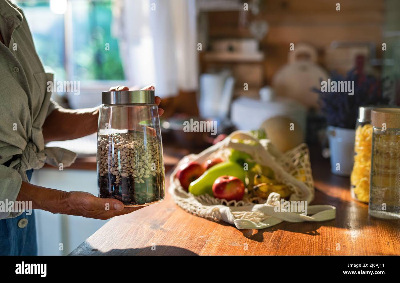 Close-up of senior woman unpacking local food in zero waste packaging ...