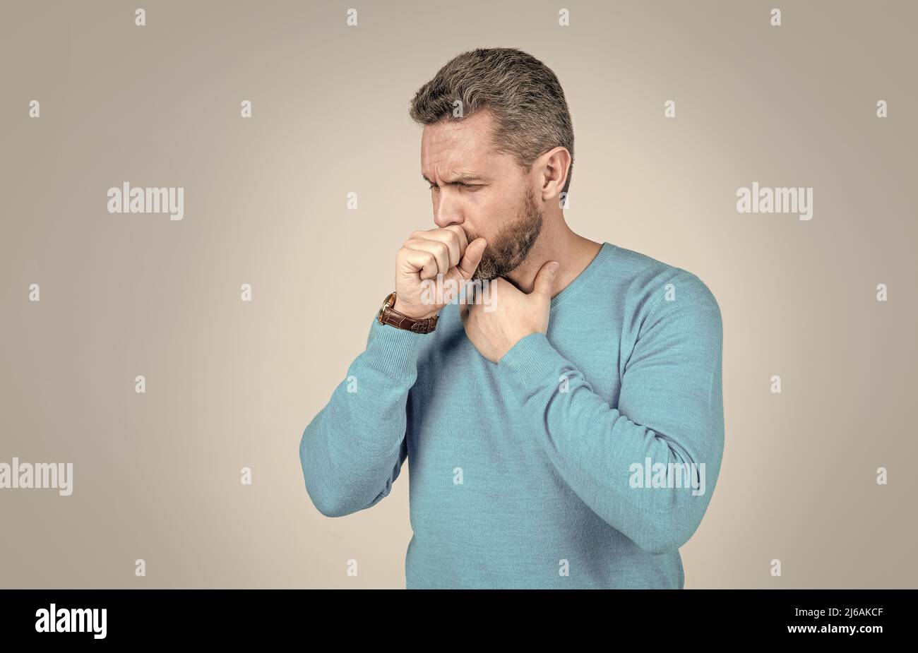 mature man with beard has cough suffer from sore throat on grey ...