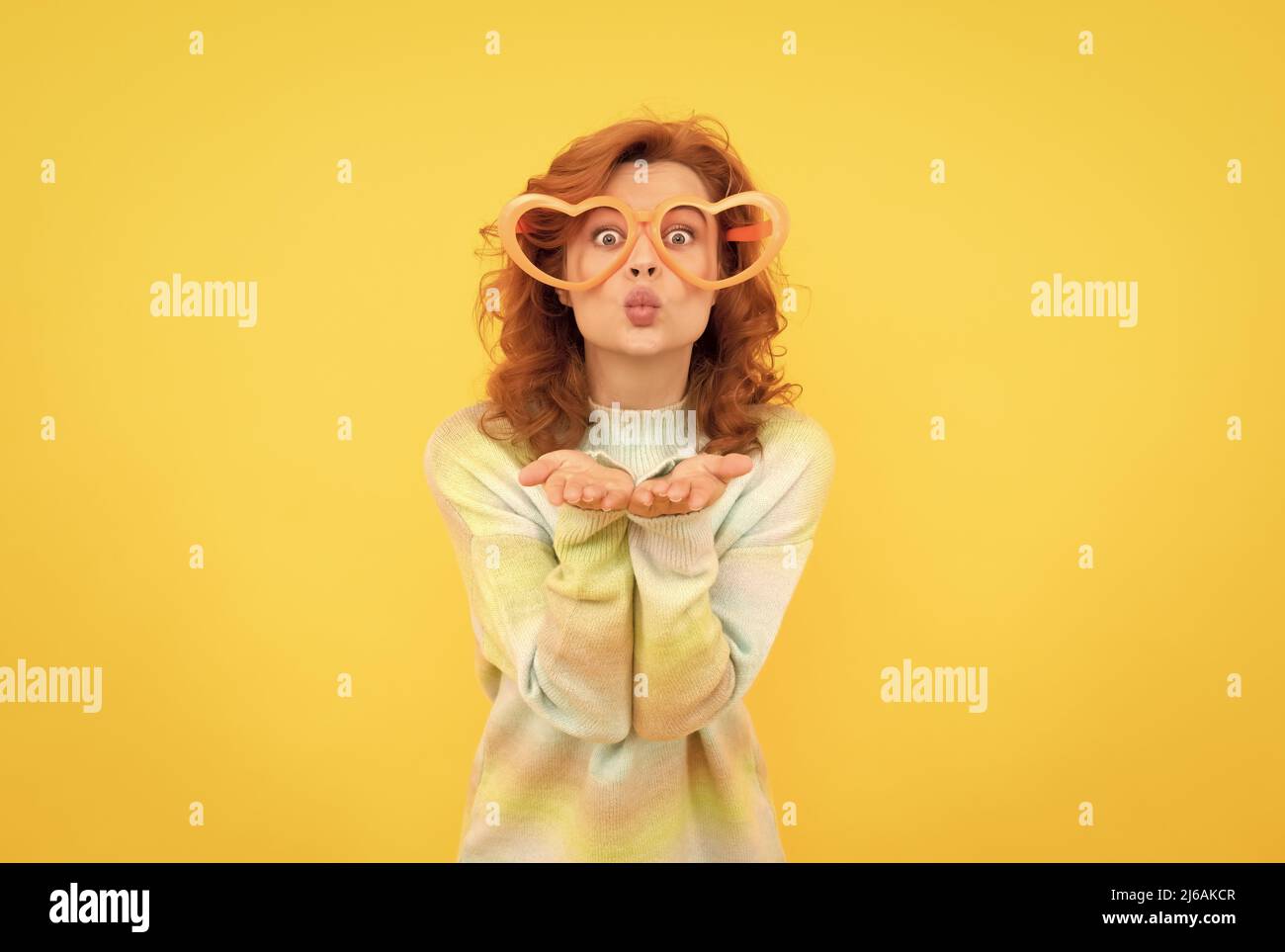 happy redhead woman wear funny party glasses send kiss on yellow ...
