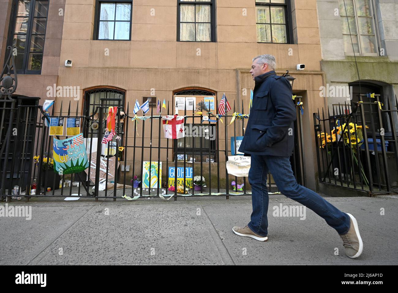 New York, USA. 29th Apr, 2022. A man walks past flowers, flags and ...