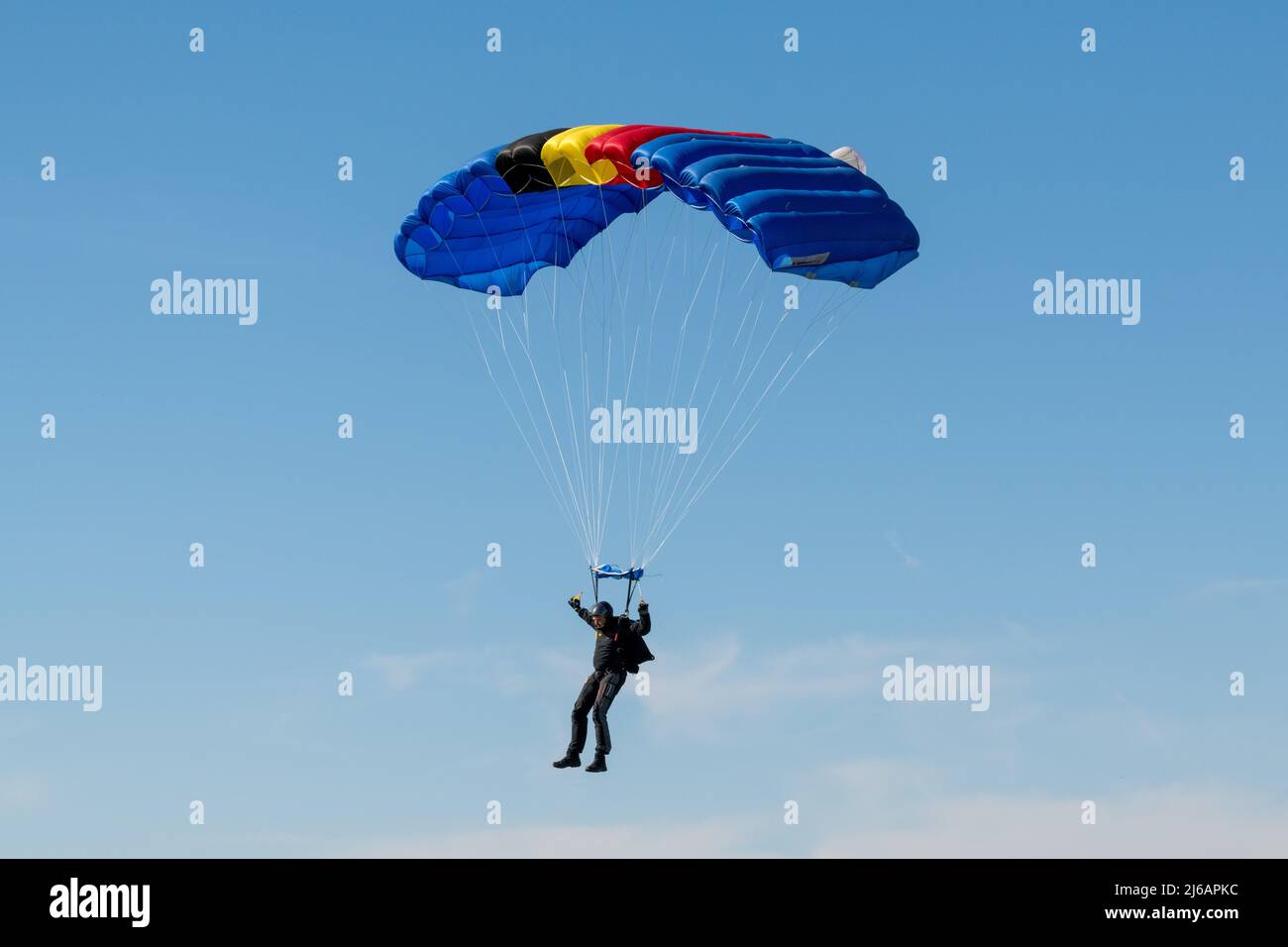 A Belgian Paratrooper performs a freefall jump as jumpmasters assigned ...