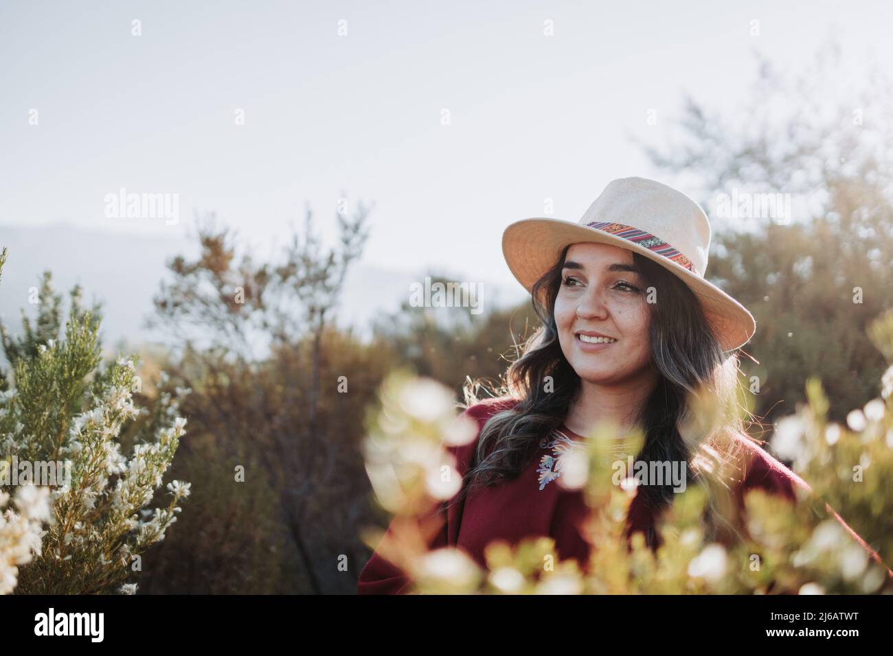 Traditional latin american woman wearing a red poncho and a hat seen ...
