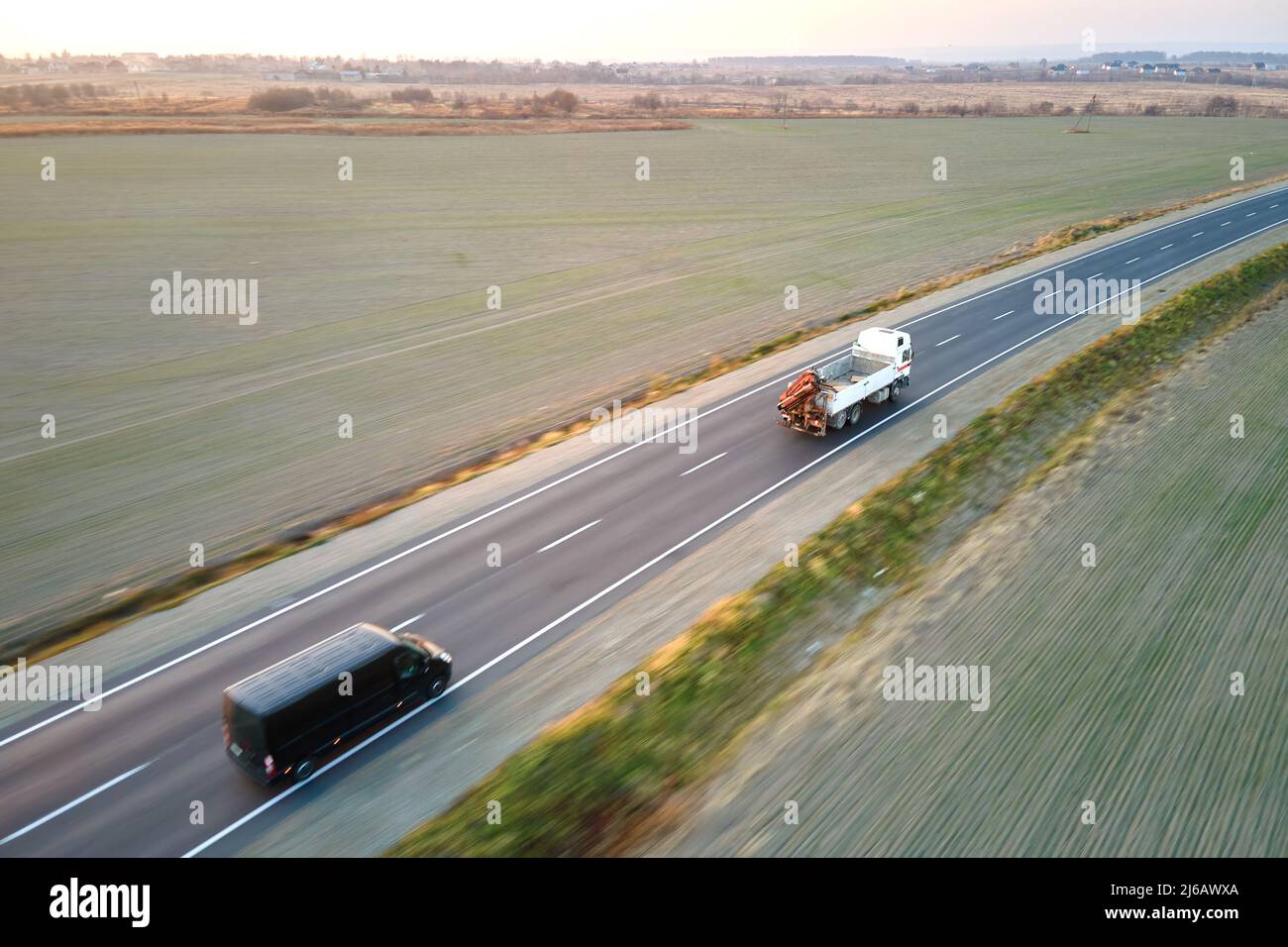 Aerial view of intercity road with fast driving cars at sunset. Top ...