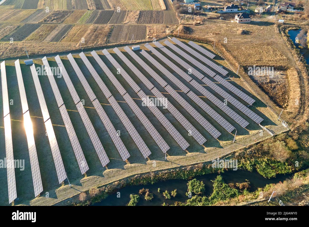 Aerial view of large sustainable electrical power plant with rows of solar photovoltaic panels ...