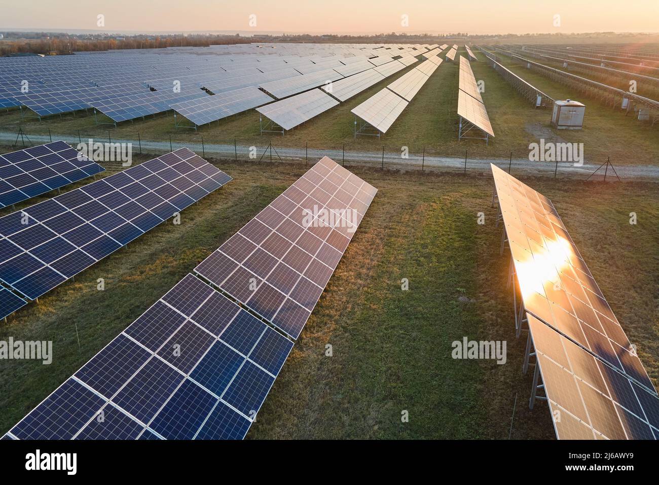 Aerial view of large sustainable electrical power plant with rows of solar photovoltaic panels ...
