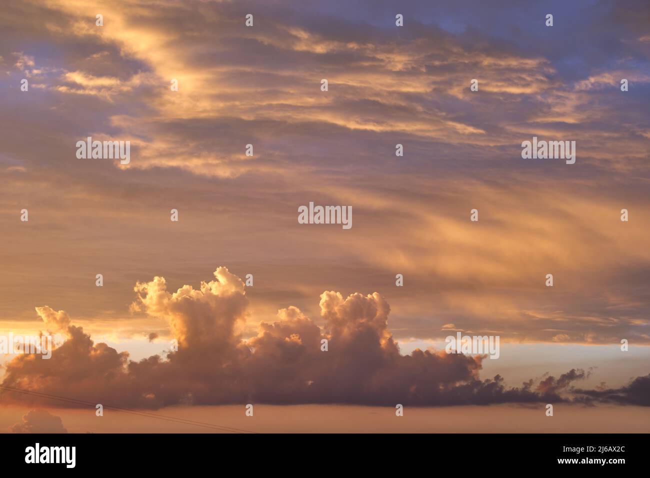 Bright colorful sunset sky with vivid smooth clouds illuminated with ...