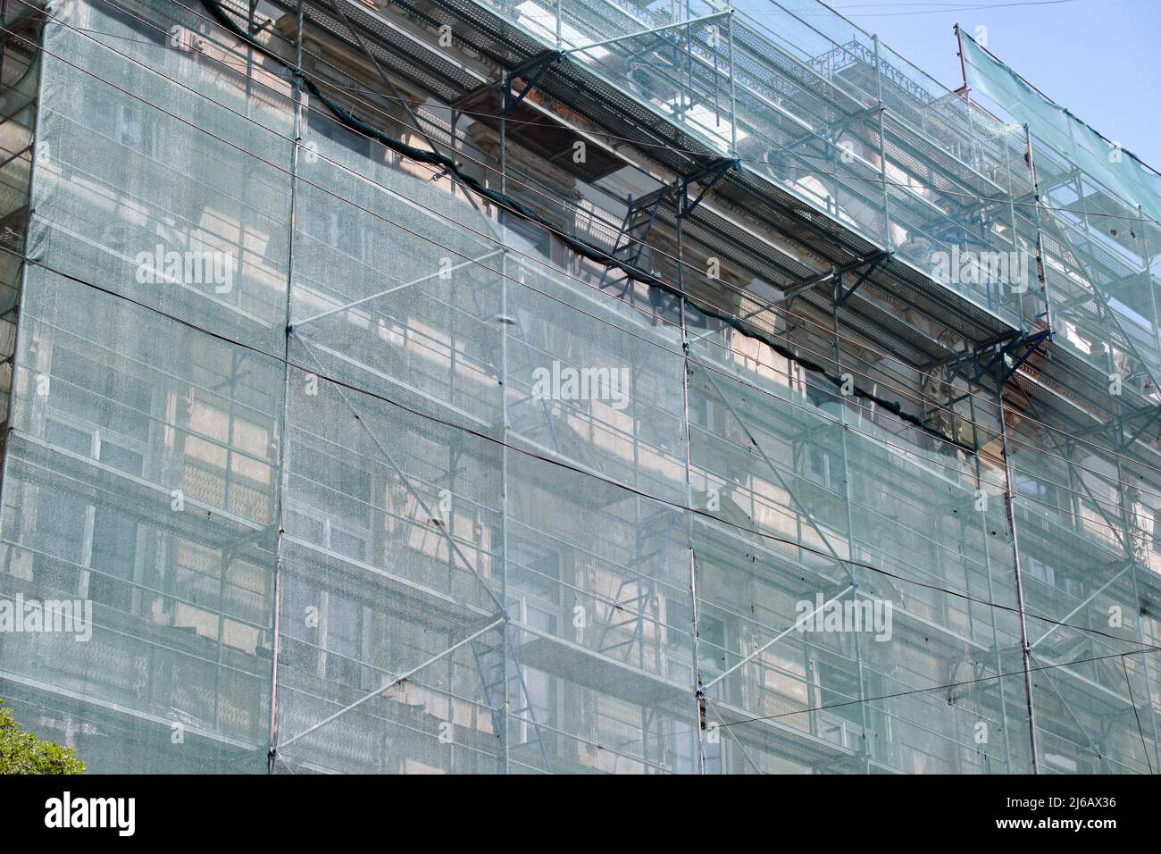 Building facade under renovation works with construction scaffolding ...