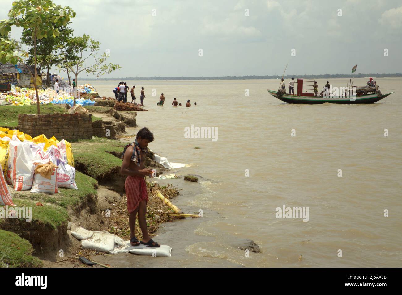 Workers cleaning themselves on the bank of Rupnarayan river before ...