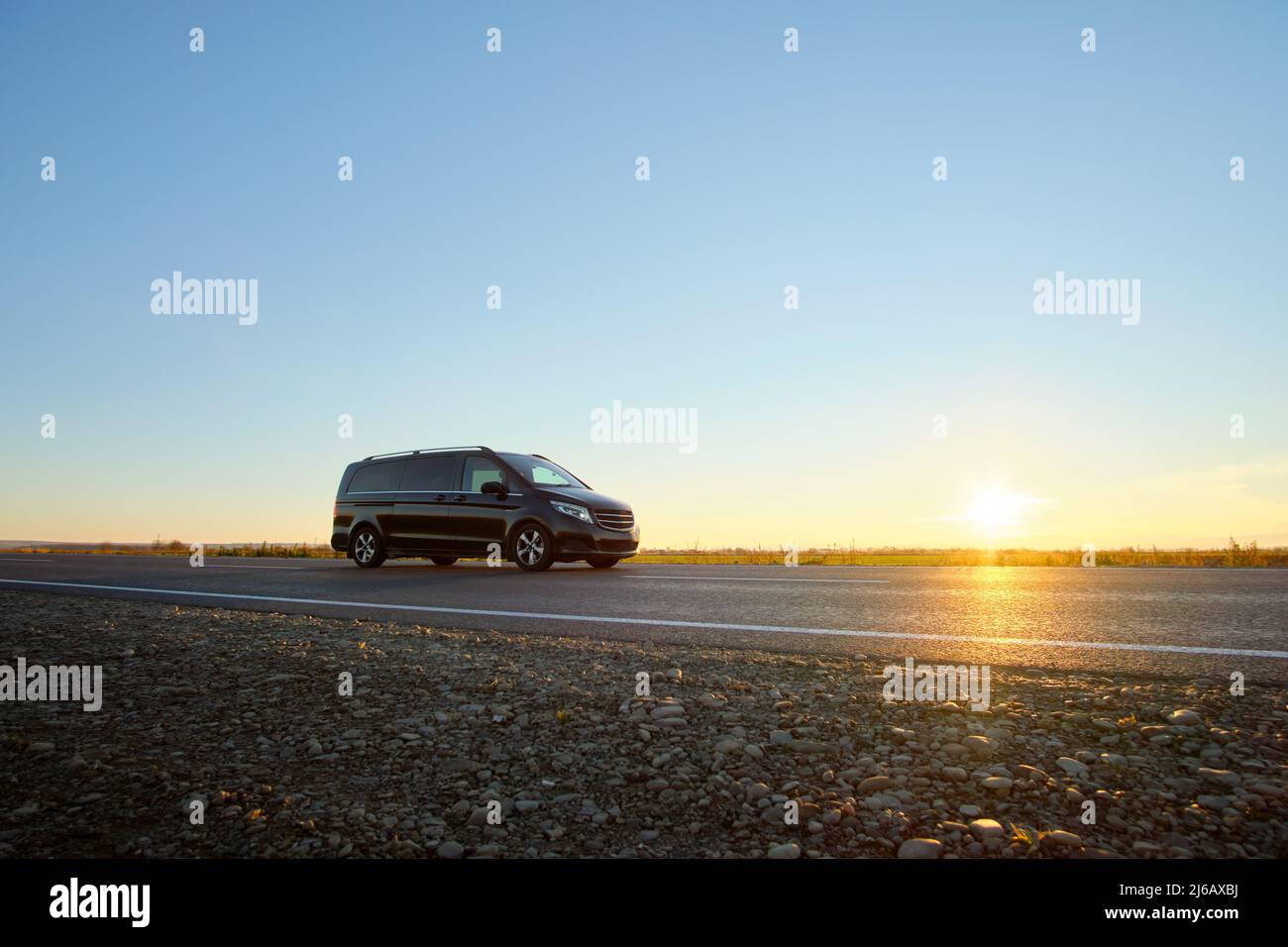 Passenger van driving fast on intercity road at sunset. Highway traffic ...
