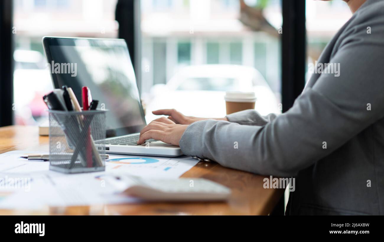 Business analyst concept the female officer typing financial ...
