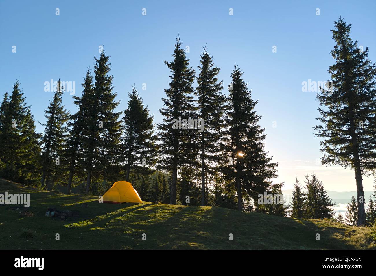 Tourist camping tent on mountain campsite at bright sunny evening ...
