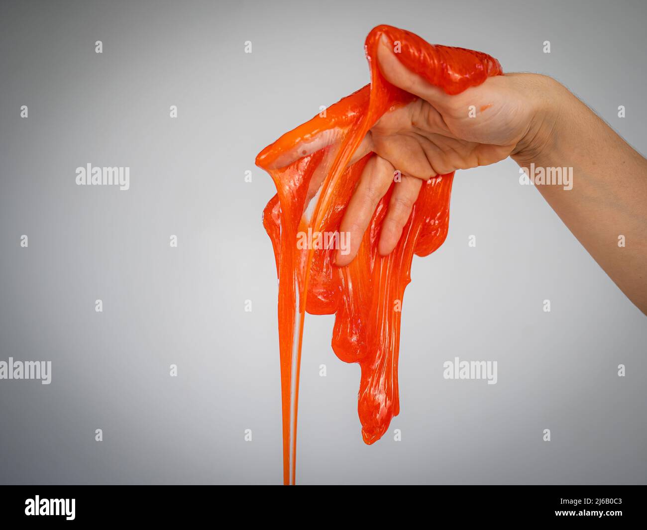 Red slime flowing down from a woman's hand on a white background Stock ...
