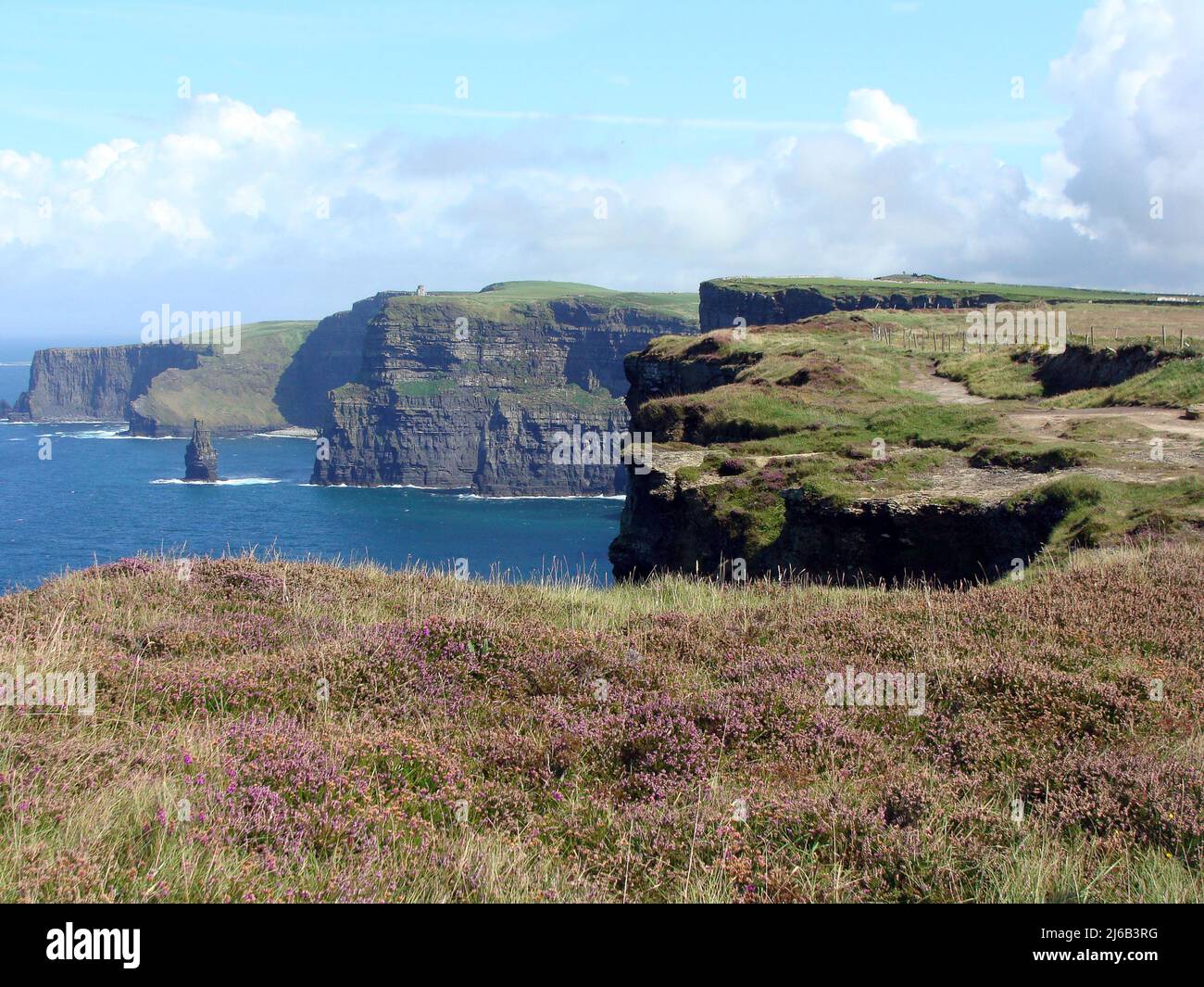 colorful ocean views, green grassy rocks, rocks and blue water. The ...