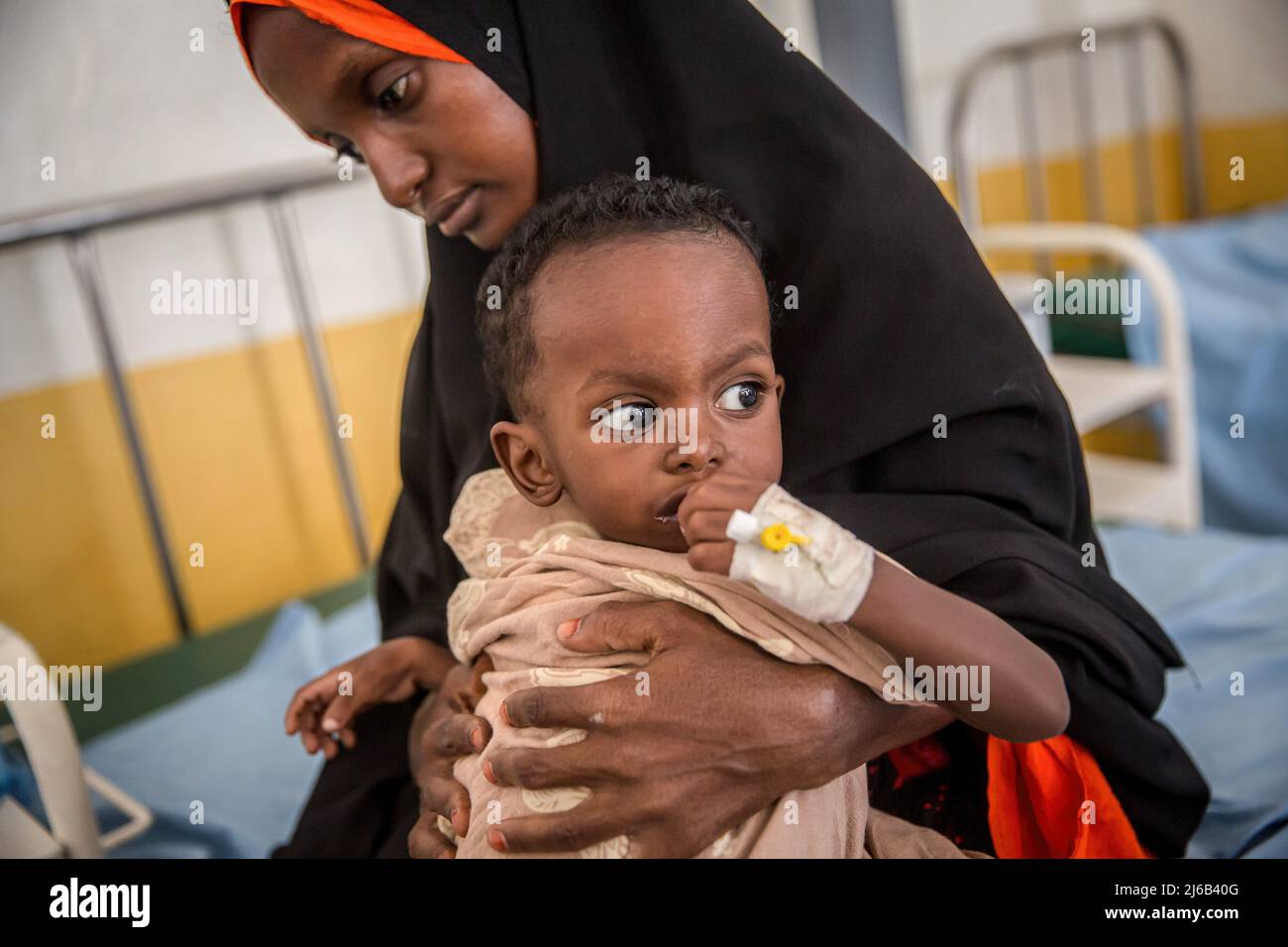 Istar Mohamed Abdi, 20, holds her malnourished 16-month-old boy in a ...