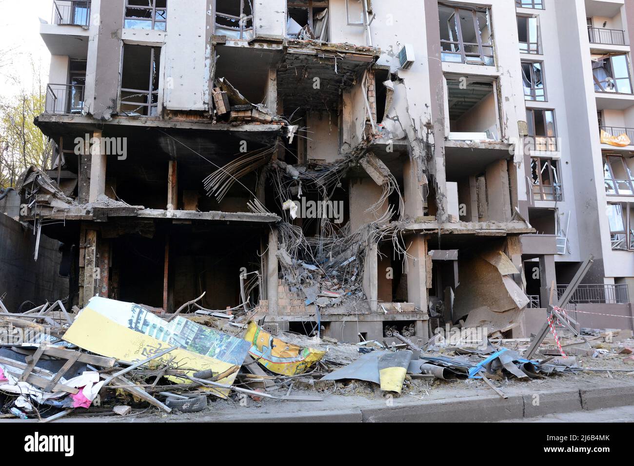 A closer view of a damaged apartment building with broken glasses in ...