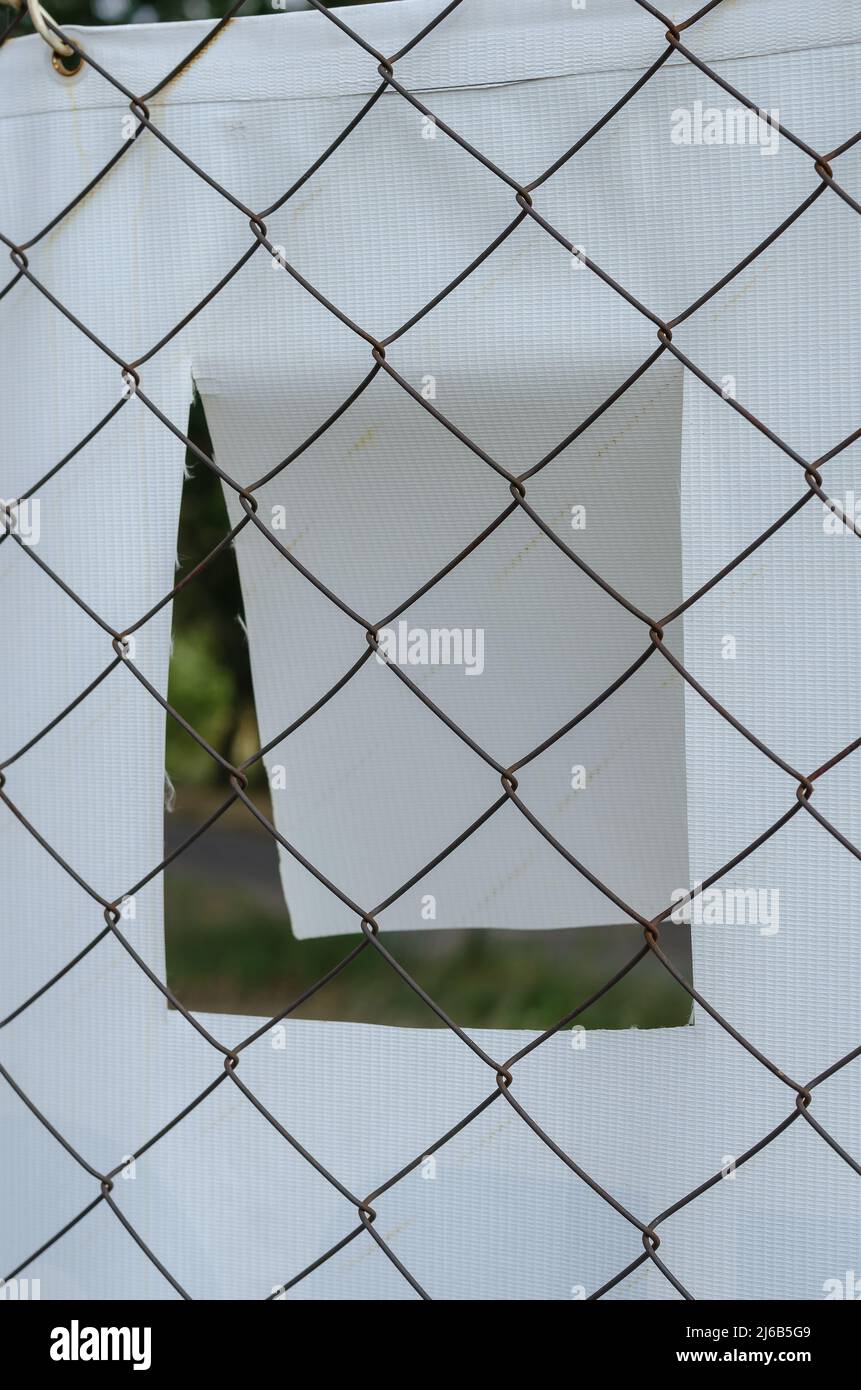 The banner is attached to Chain-link fencing. White banner with ...