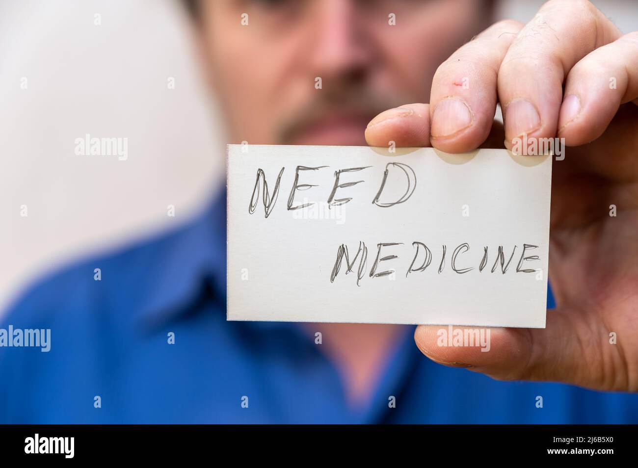 Need medicine. It is written in jagged gray letters on the paper. Man ...