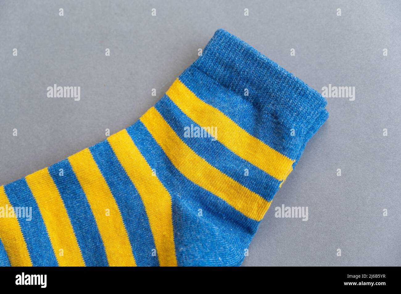 Blue and yellow socks against a gray background. A pair of bright ...