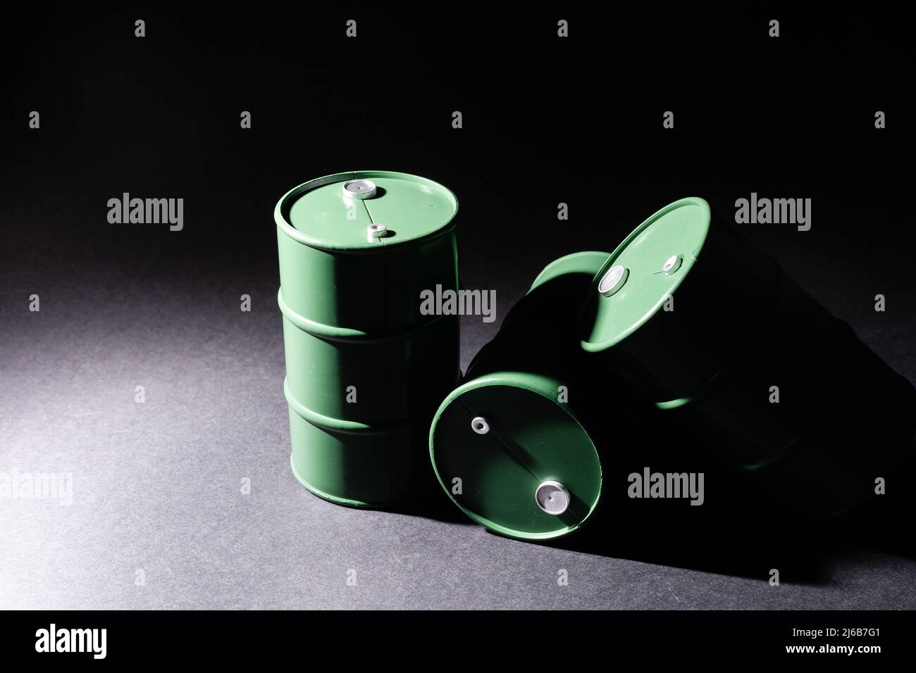 green oil tin barrels on black background Stock Photo - Alamy