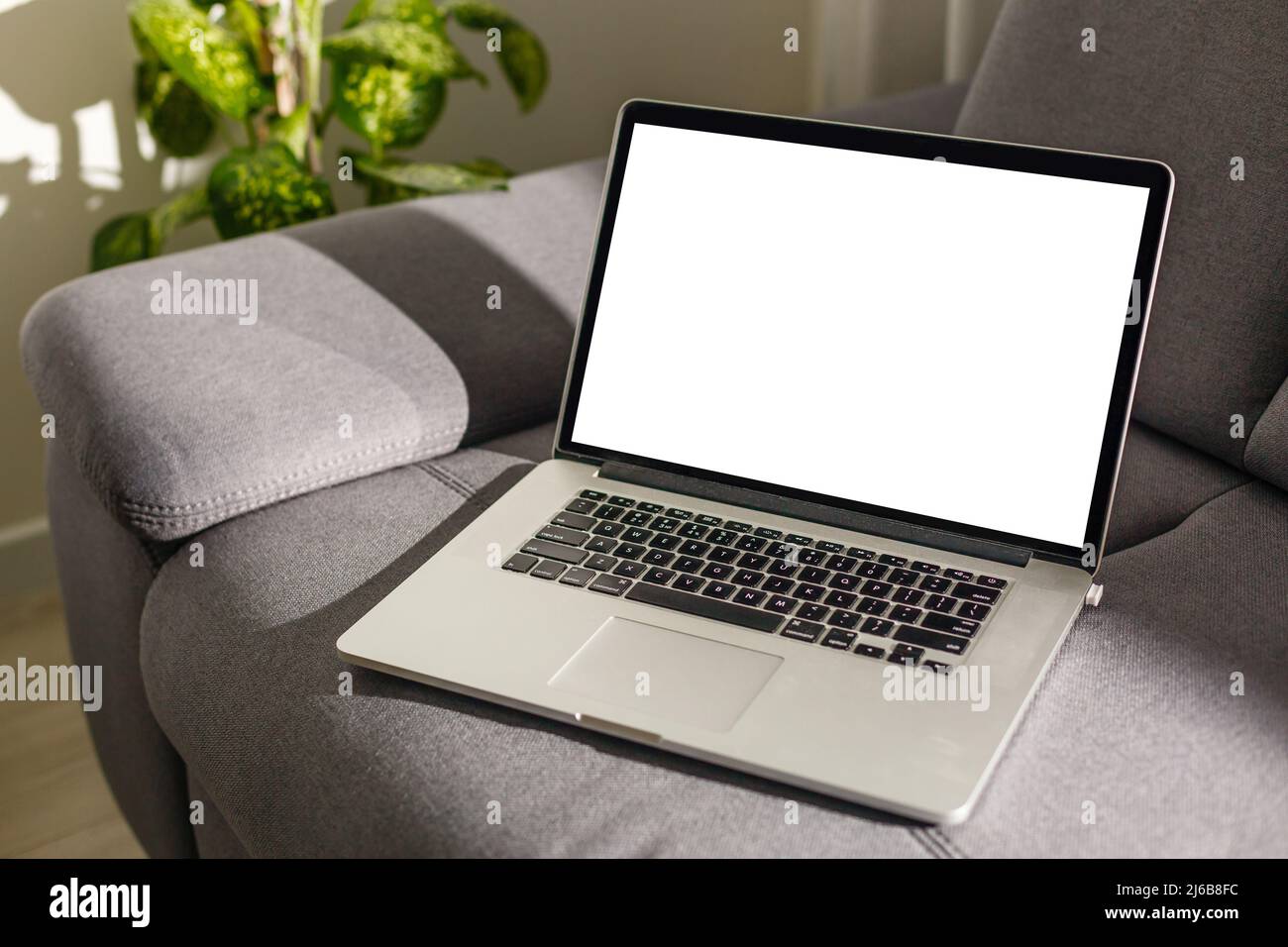 Blank screen laptop computer on sofa Stock Photo - Alamy