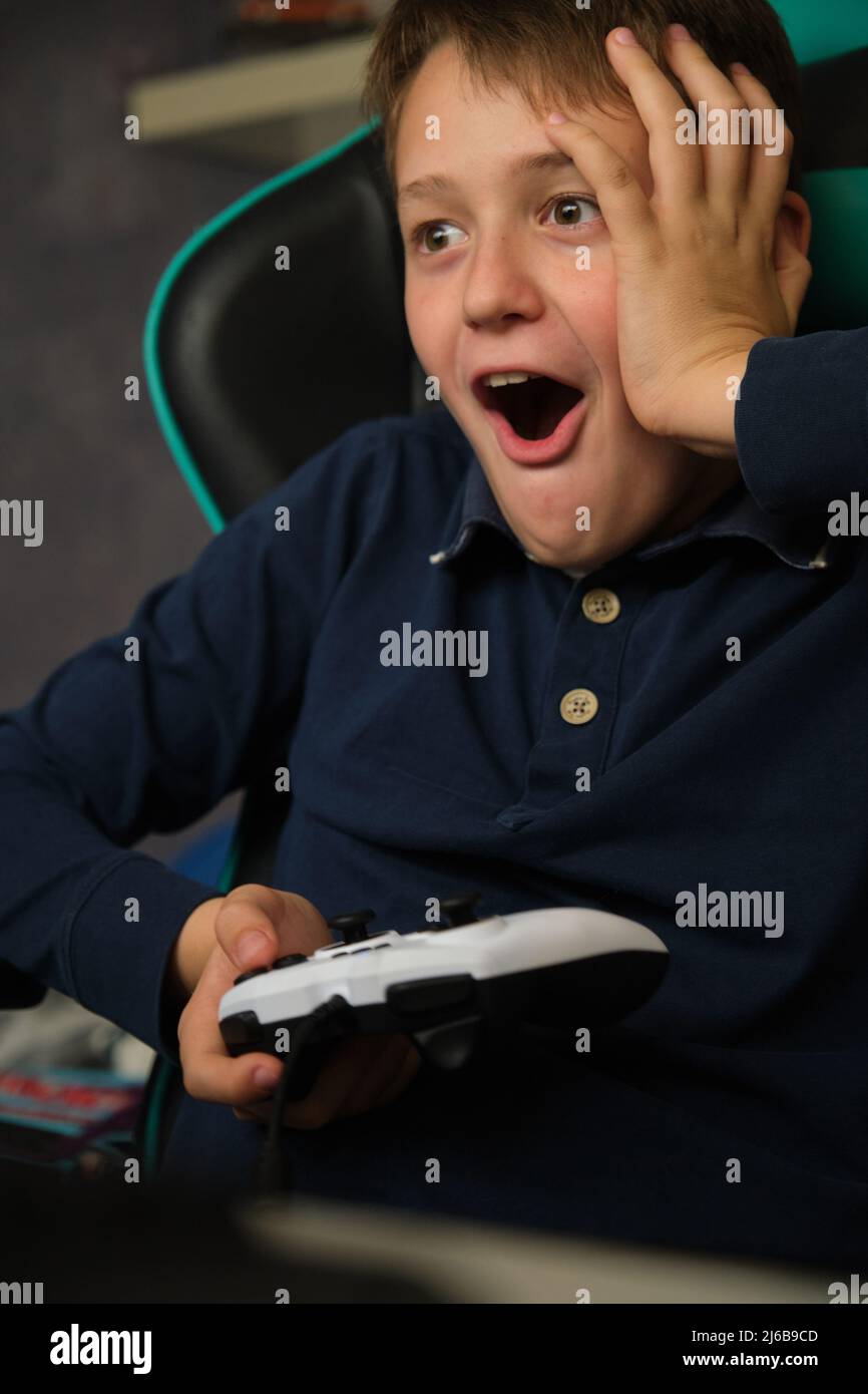 the boy is playing a video game console Stock Photo - Alamy