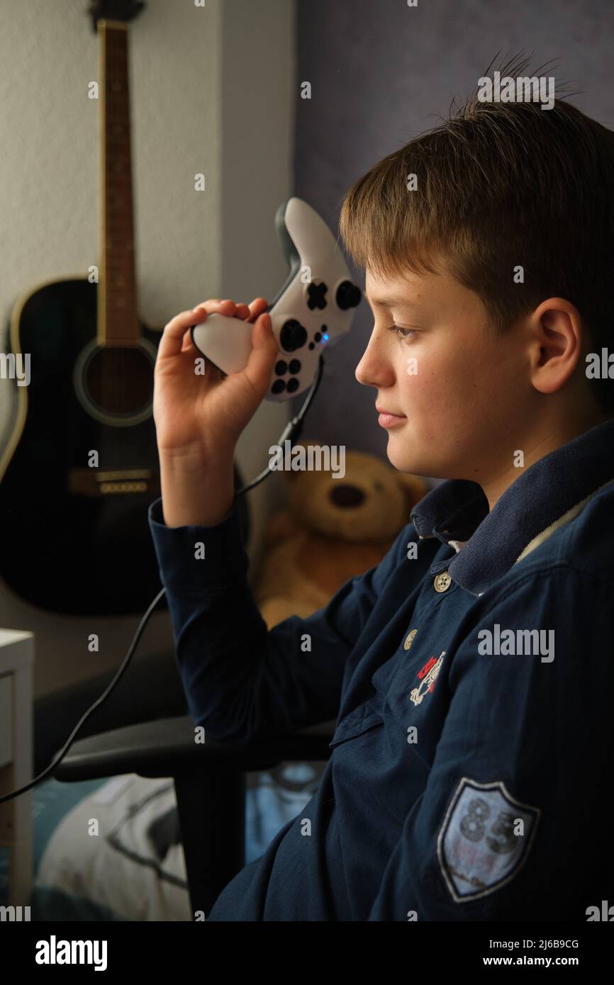 the boy is playing a video game console Stock Photo - Alamy