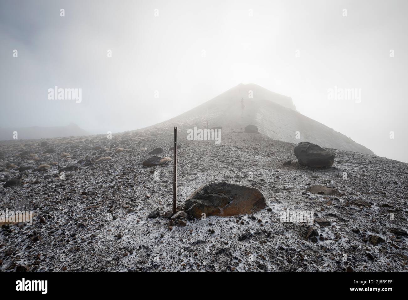 Steep scree path to the Red Crater summit in the heavy fog on Tongariro ...