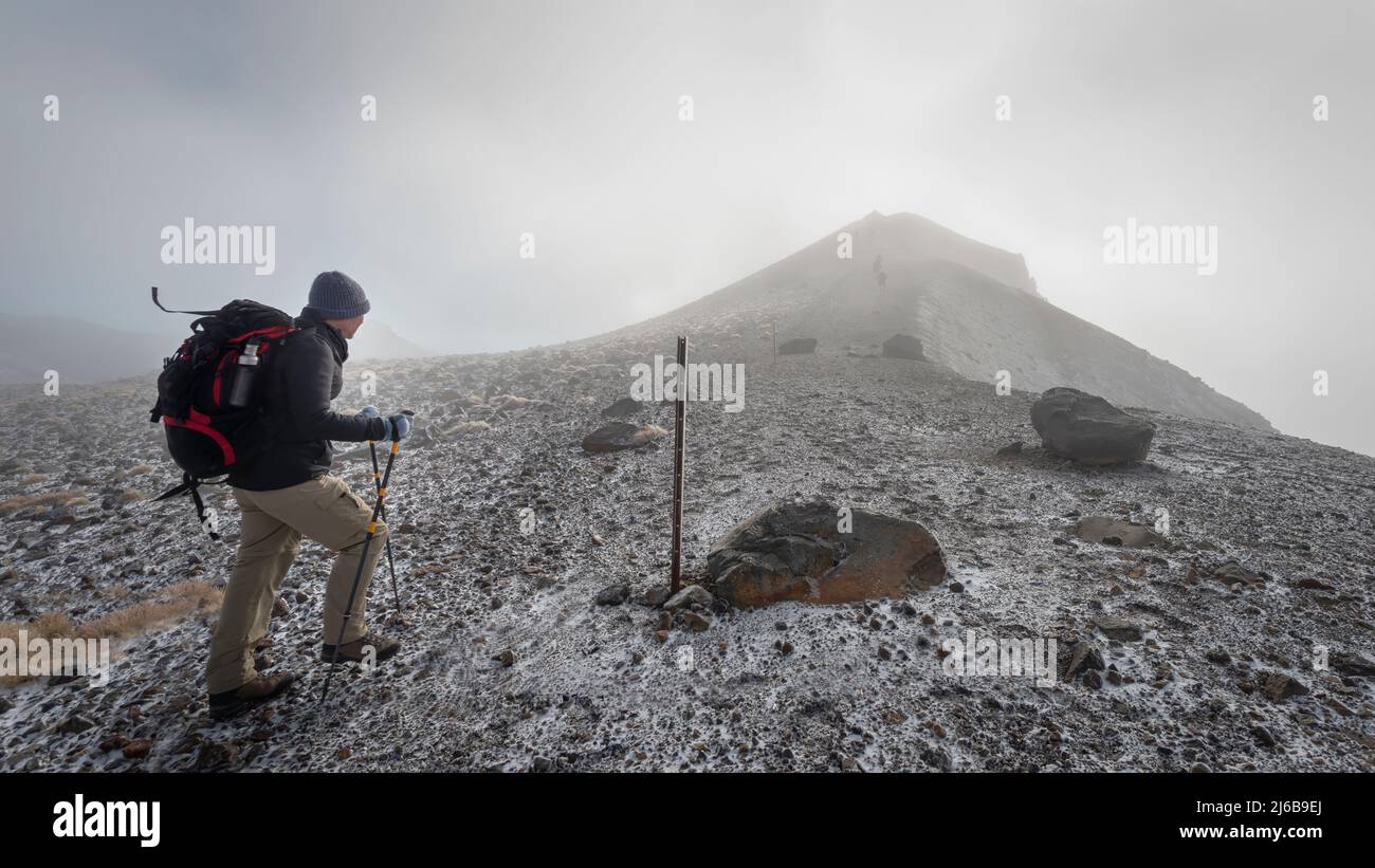 Hiking the steep scree terrain to the Red Crater summit with strong ...