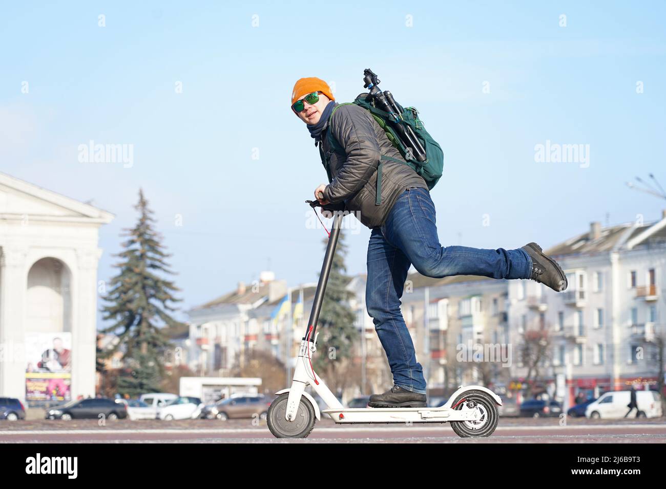 The guy stands with one foot on an electric scooter Stock Photo - Alamy