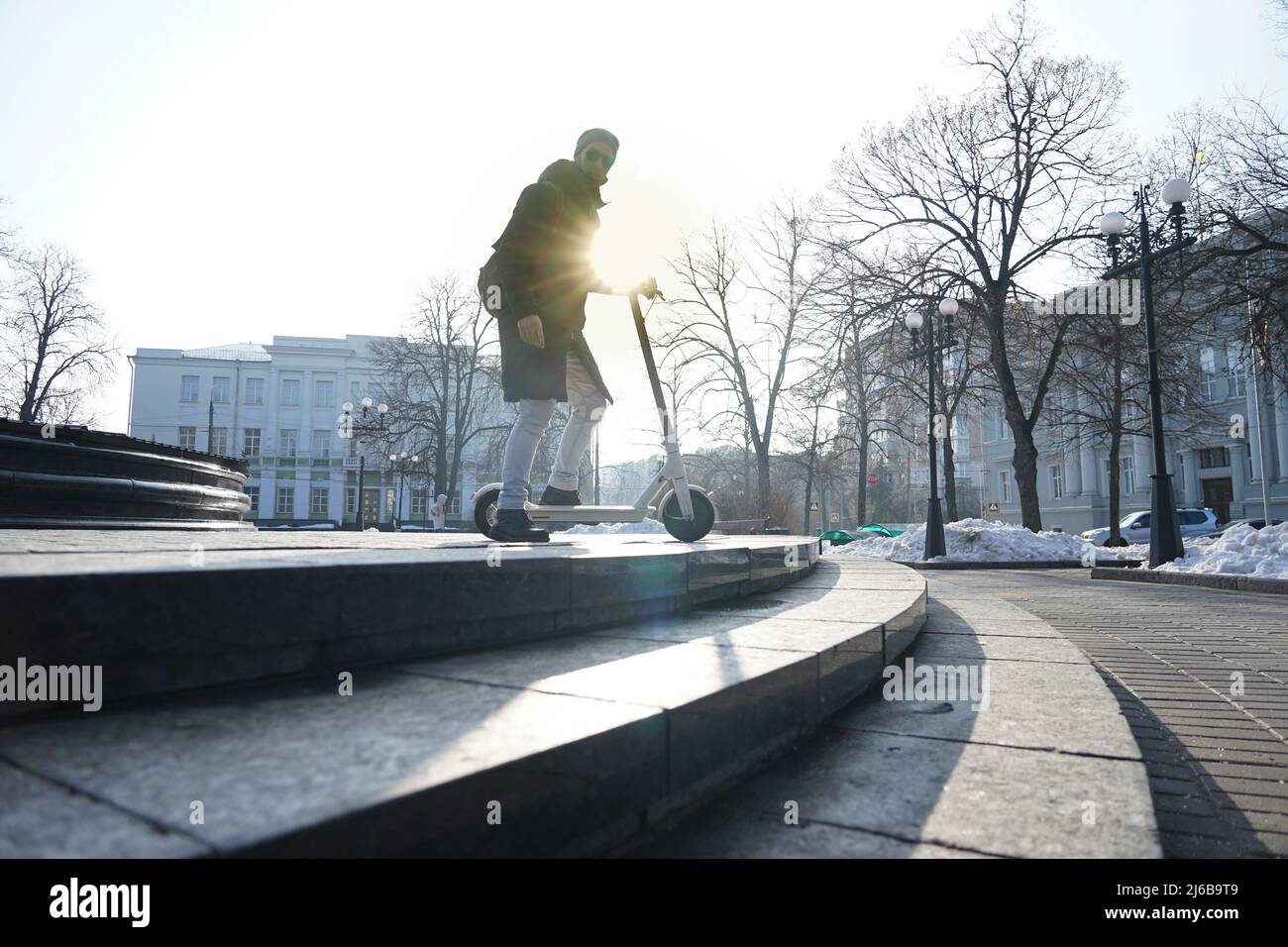 The guy stands with one foot on an electric scooter Stock Photo - Alamy
