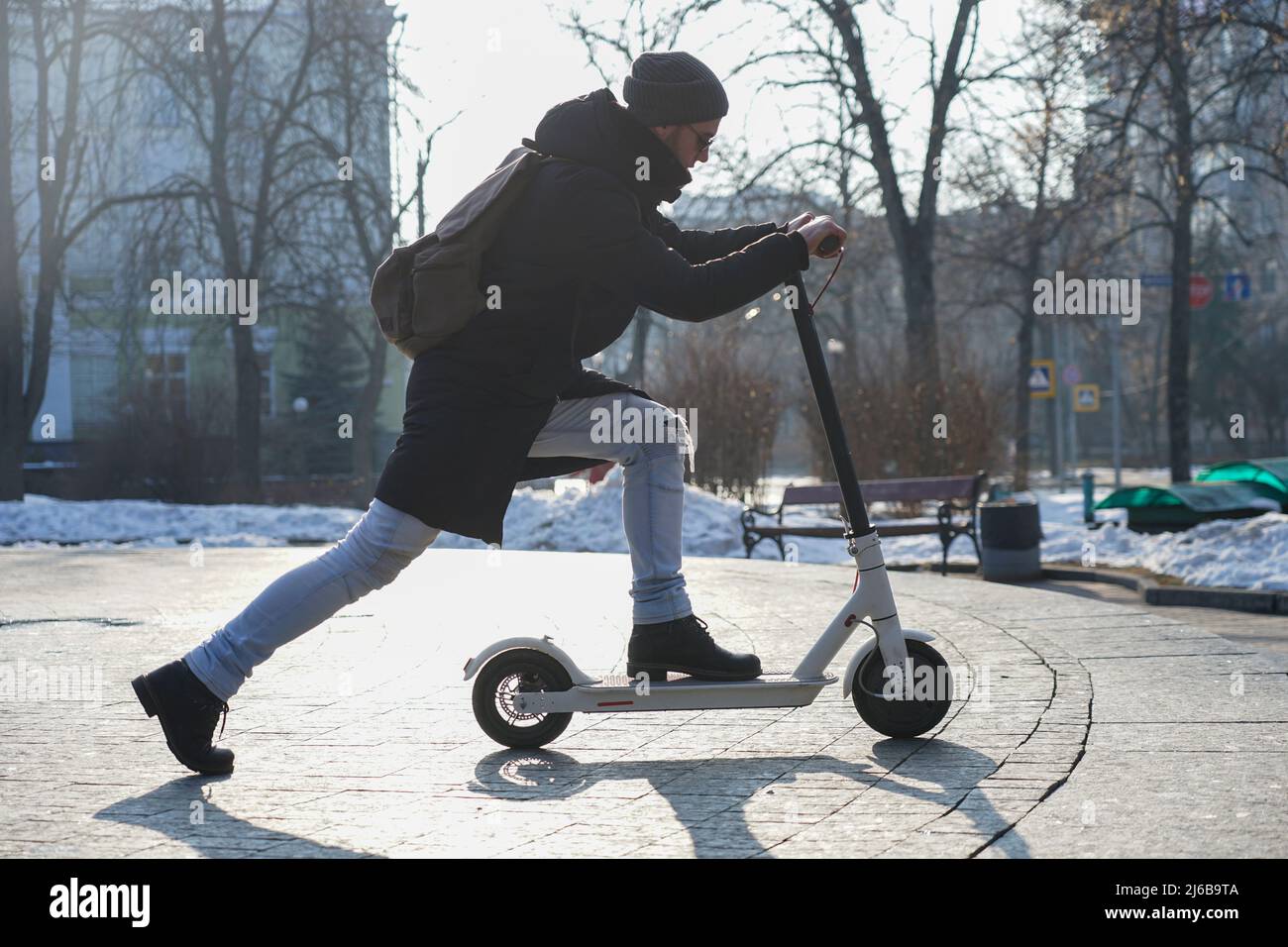 The guy stands with one foot on an electric scooter Stock Photo - Alamy