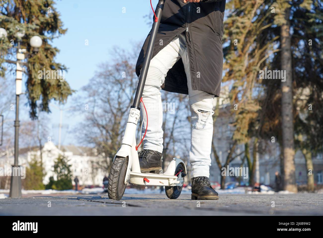 The guy stands with one foot on an electric scooter Stock Photo - Alamy