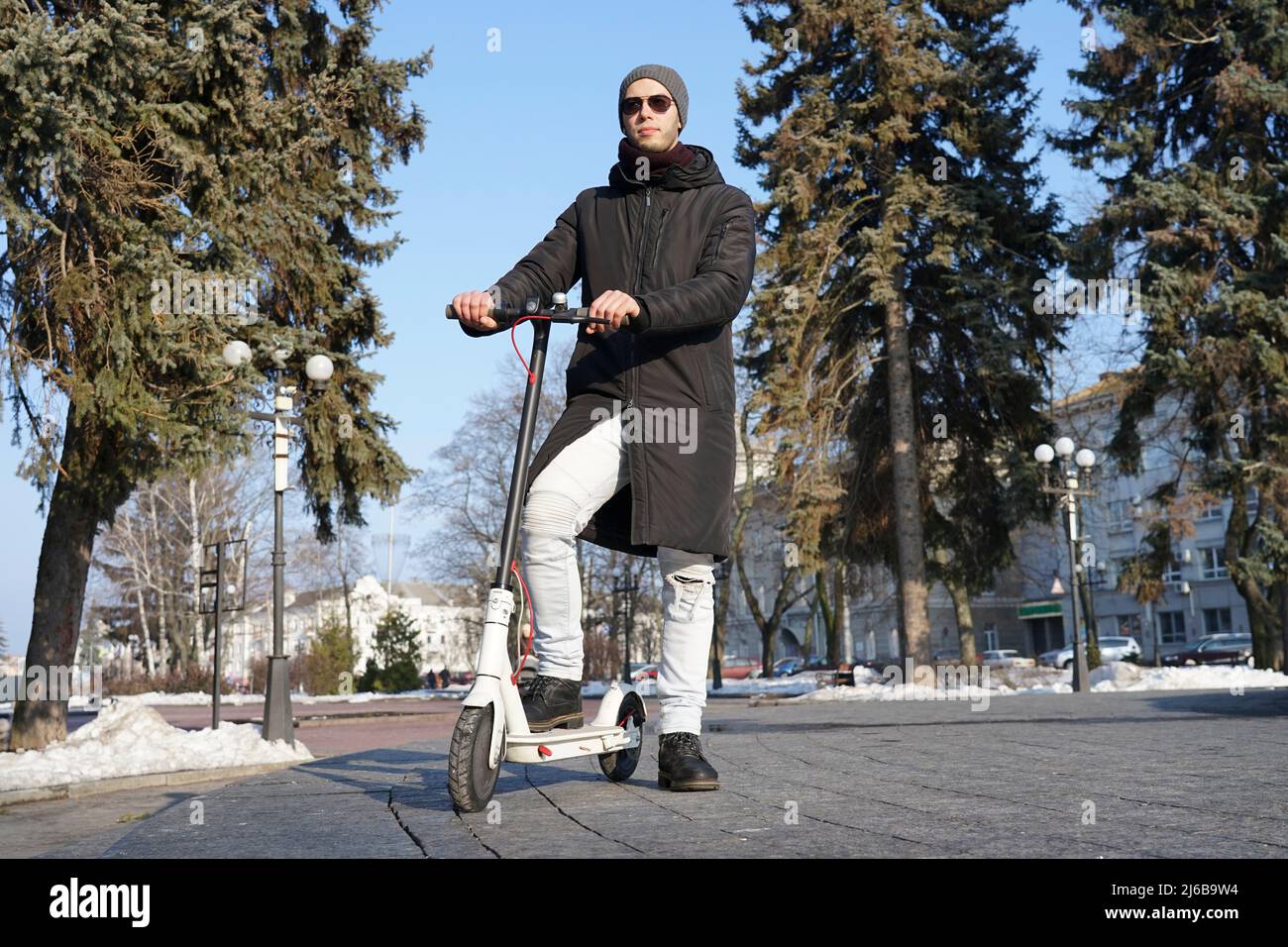 The guy stands with one foot on an electric scooter Stock Photo - Alamy