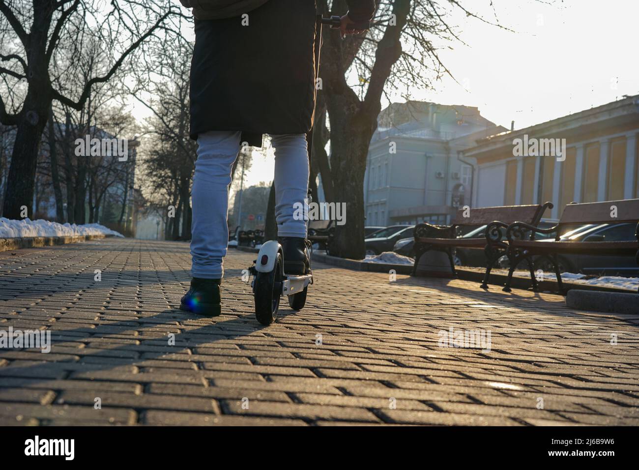 The guy stands with one foot on an electric scooter Stock Photo - Alamy