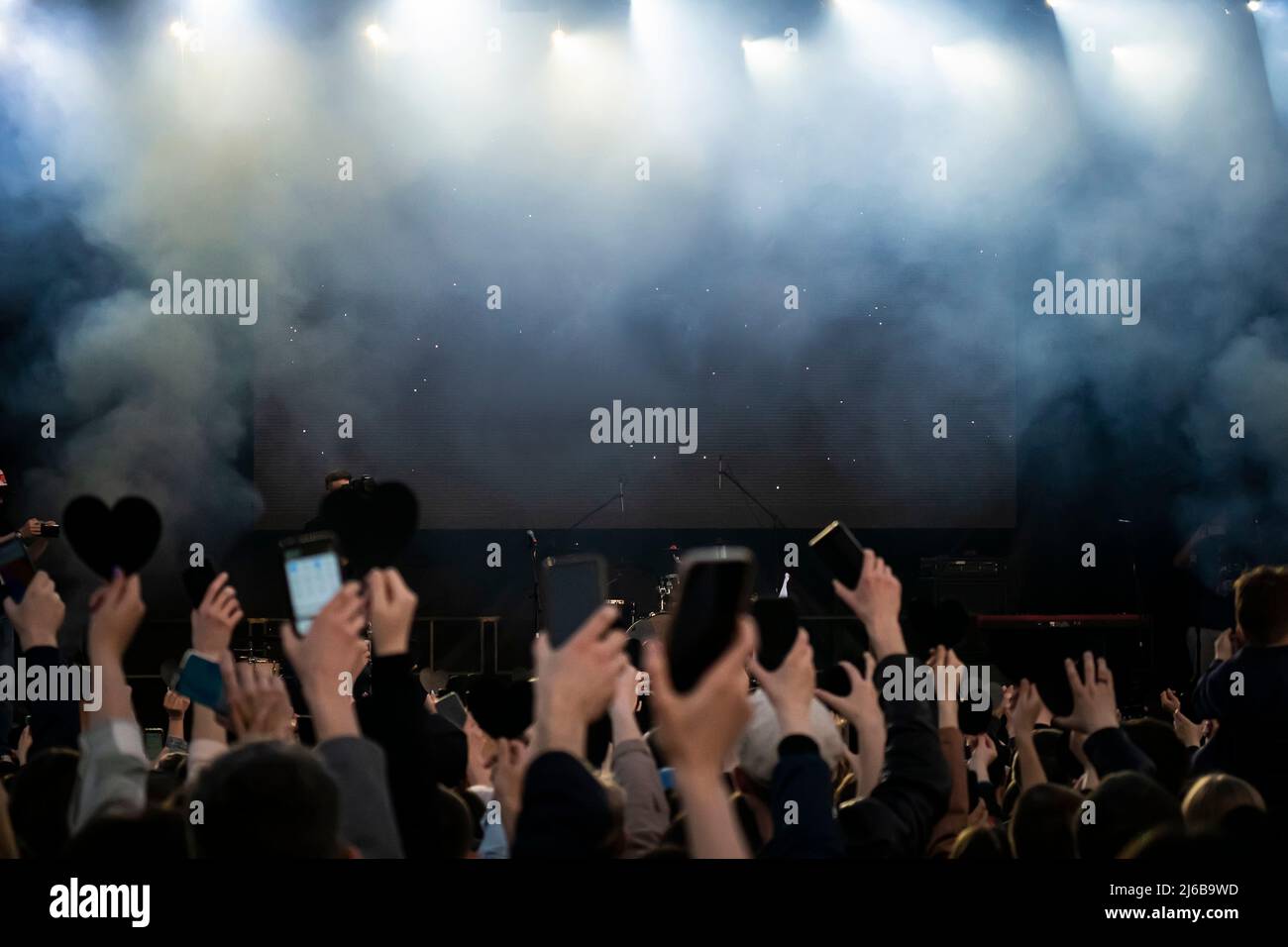 Hands raised up at big open air concert with the crowd background. A ...