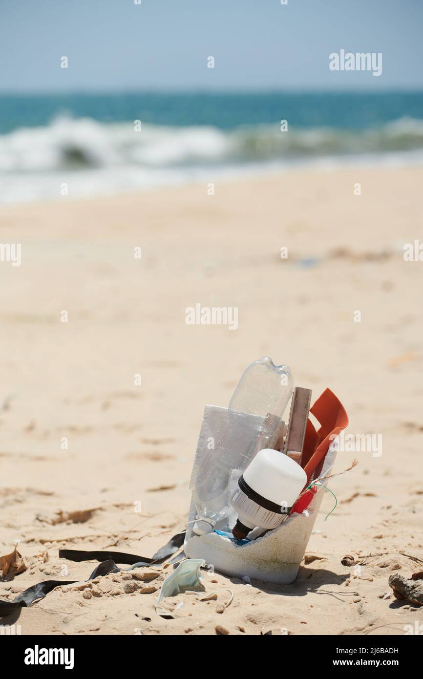 Broken bucket with plastic trash on sandy beach,marine debris and ...