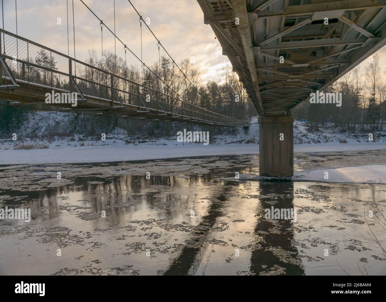 landscape with a river in winter, in the backlight of the bridge ...