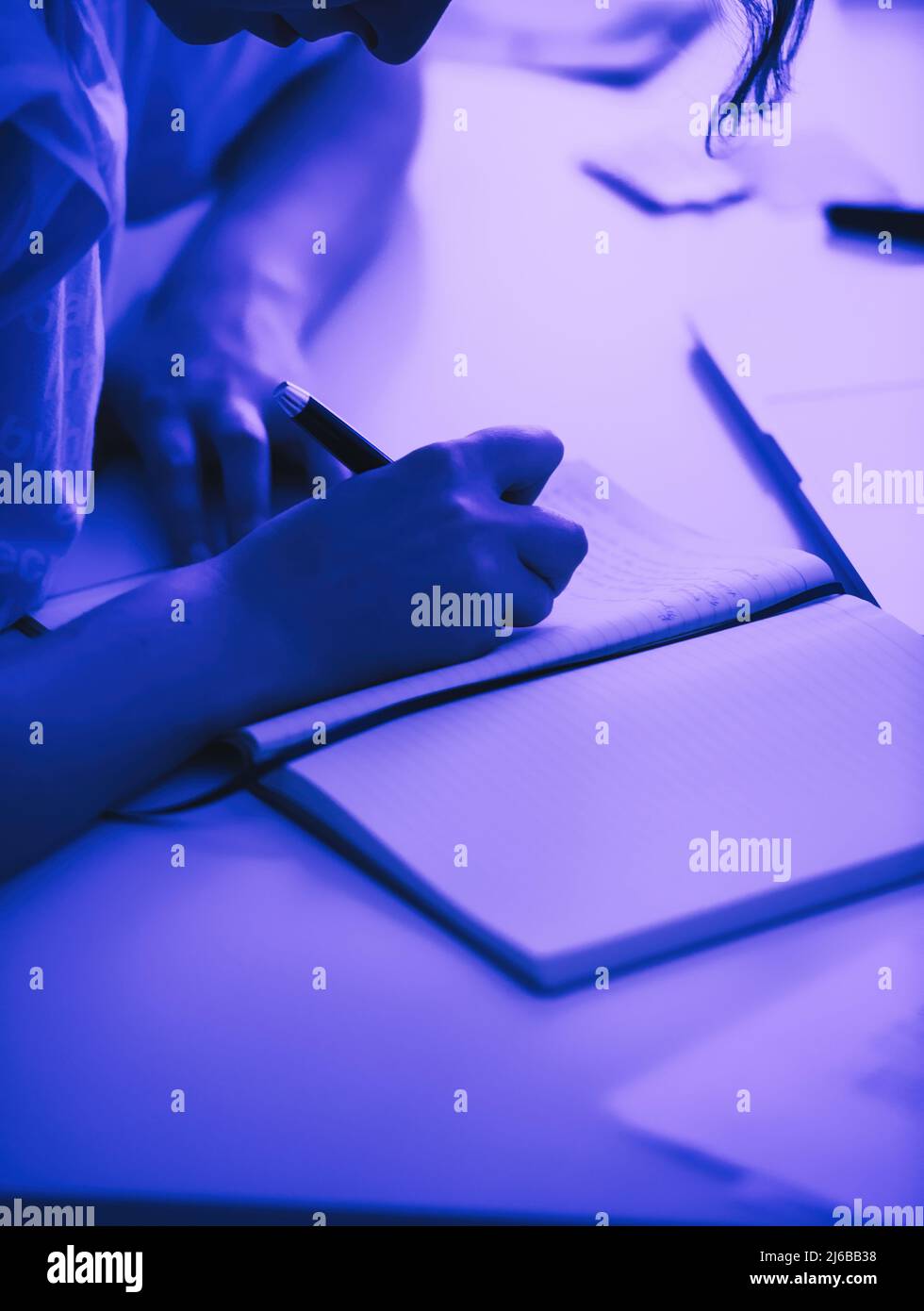 Side view of pensive enigmatic woman writing with fountain pen in ther ...