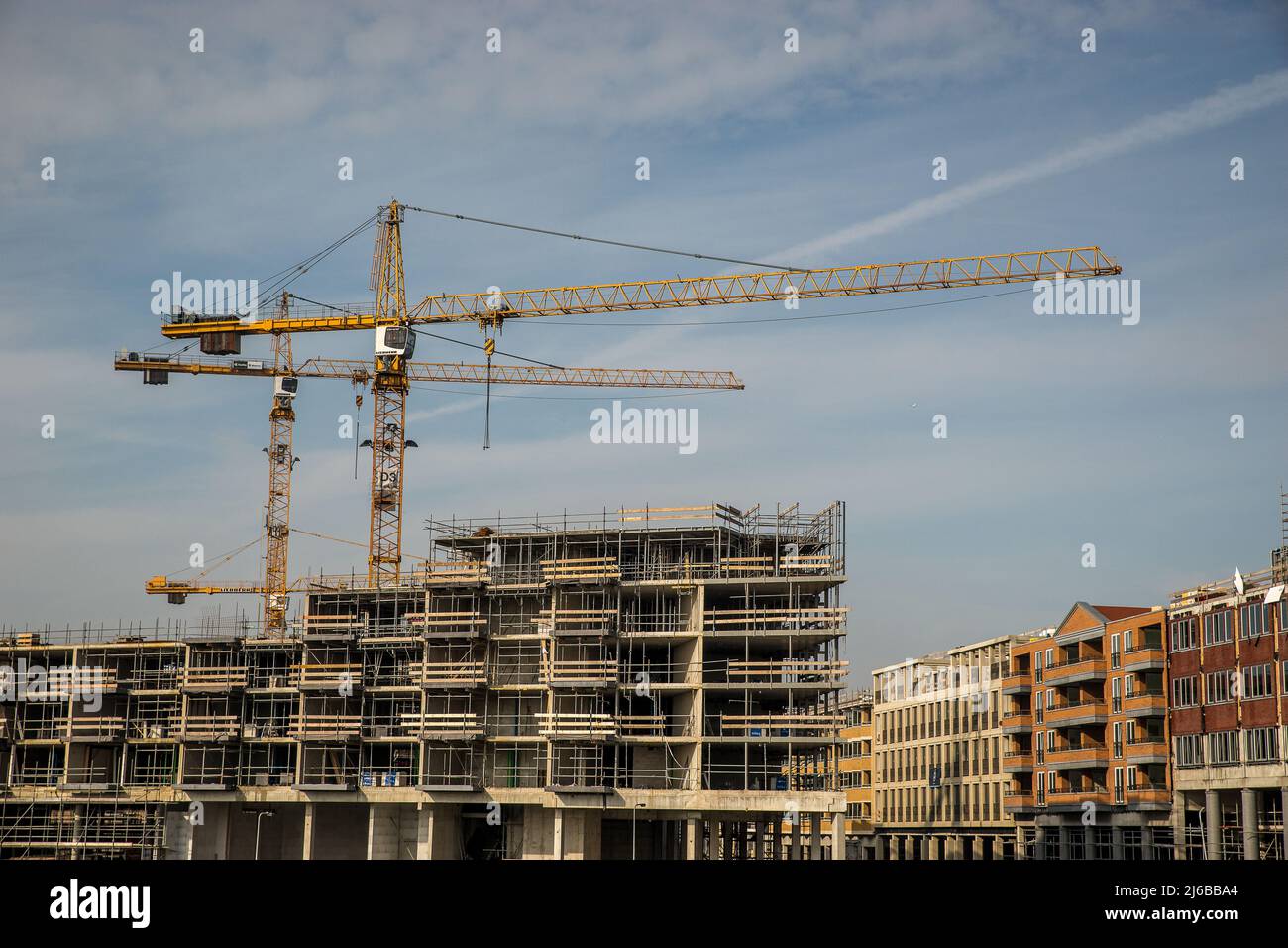 Building site with cranes and scaffolding Stock Photo - Alamy